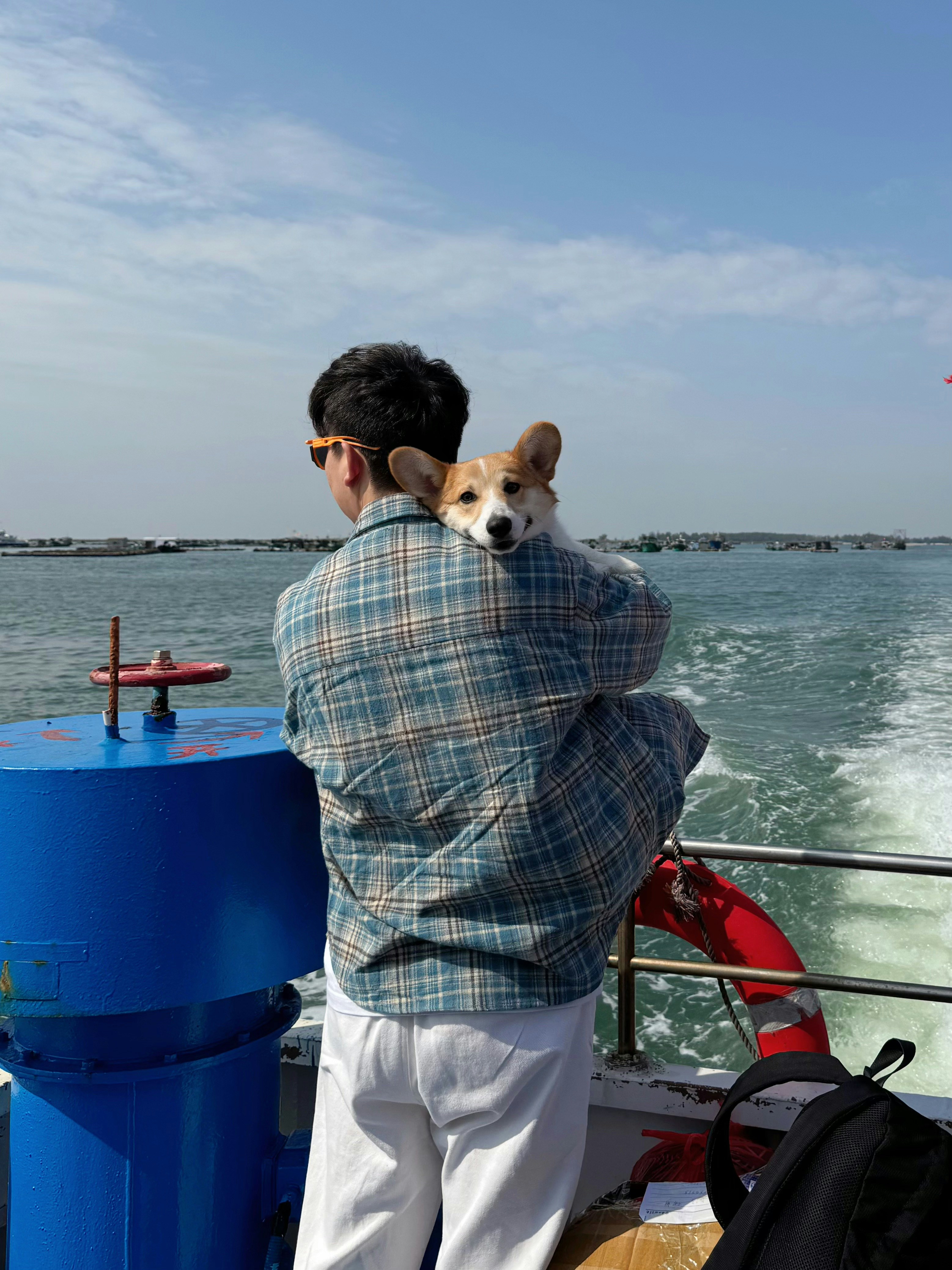 A man carries his dog while riding a boat. photo – Free Dog Image on ...