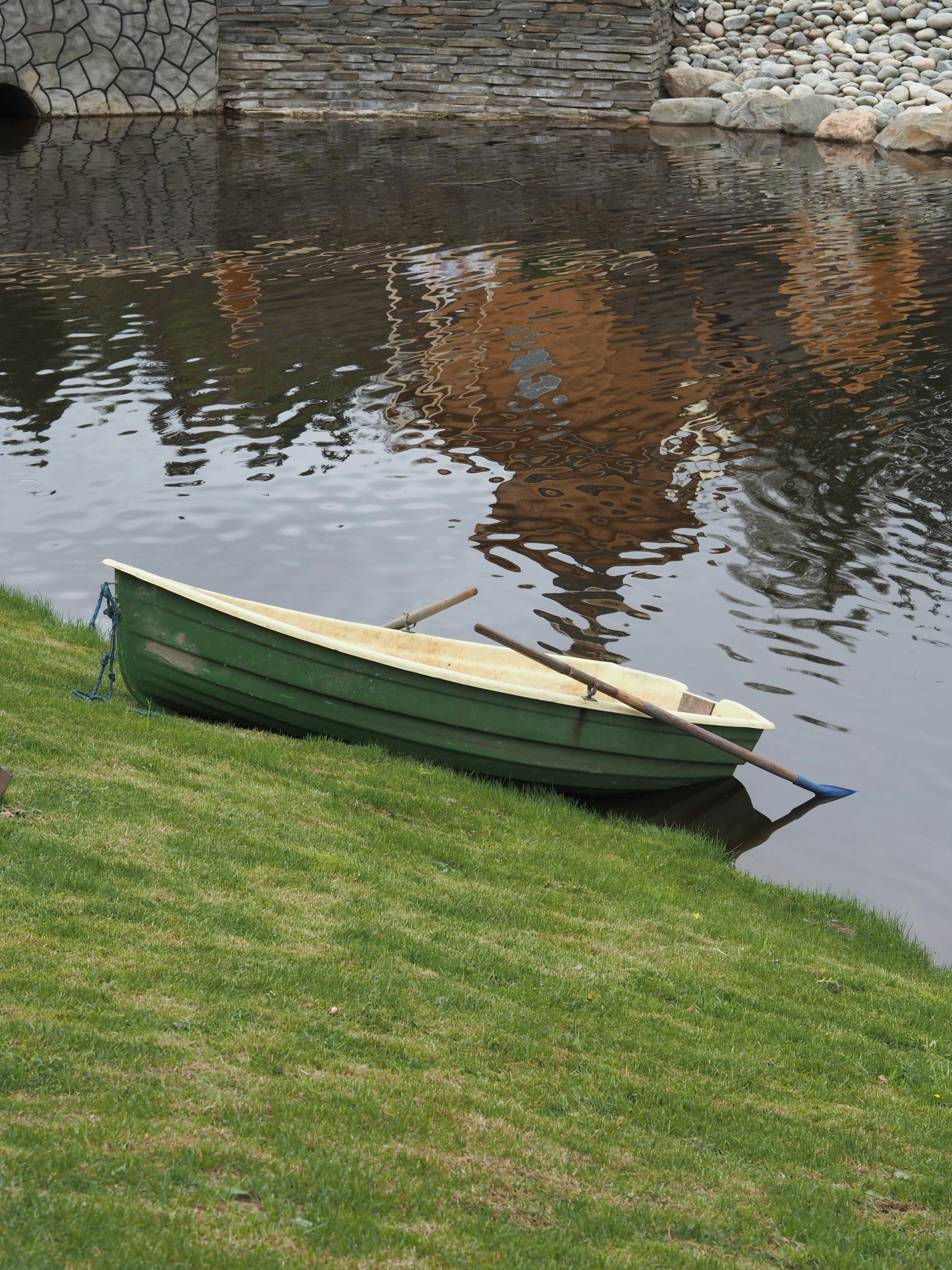 Green Rowboat by the Quiet Riverbank