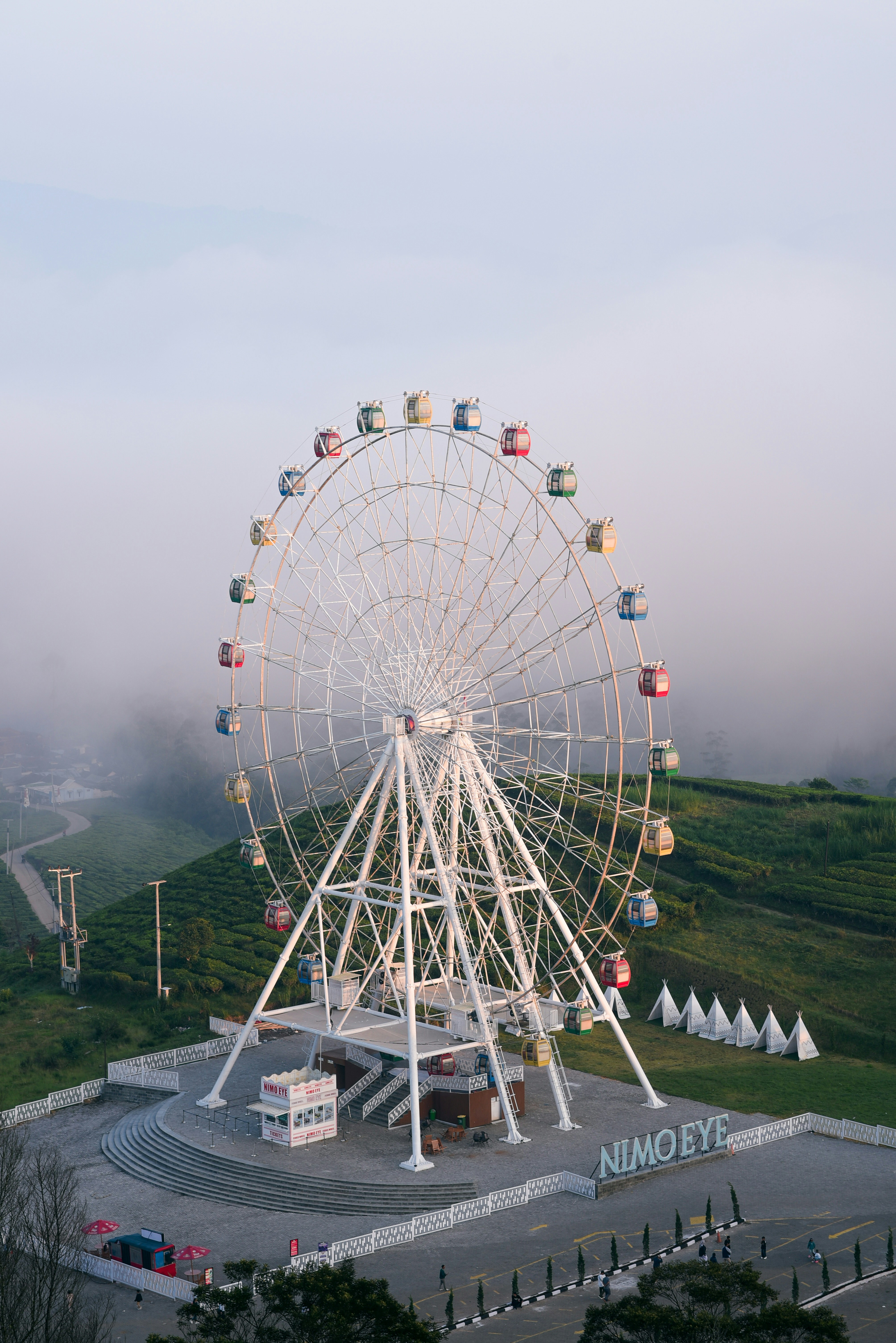 A ferris wheel stands tall amidst the morning fog. photo – Free Green ...