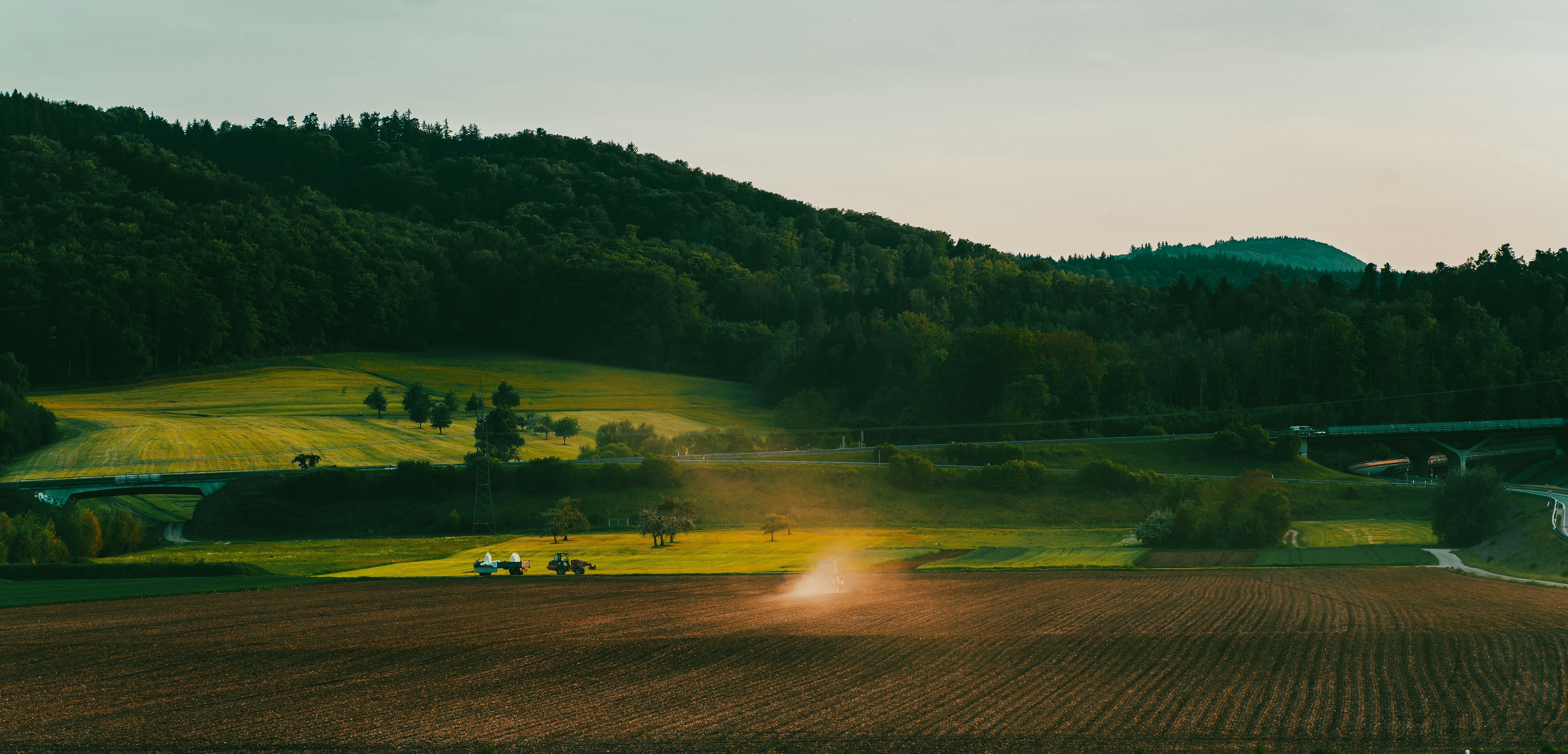 Dusty field in front of a lush green landscape. photo – Free Wallpaper ...