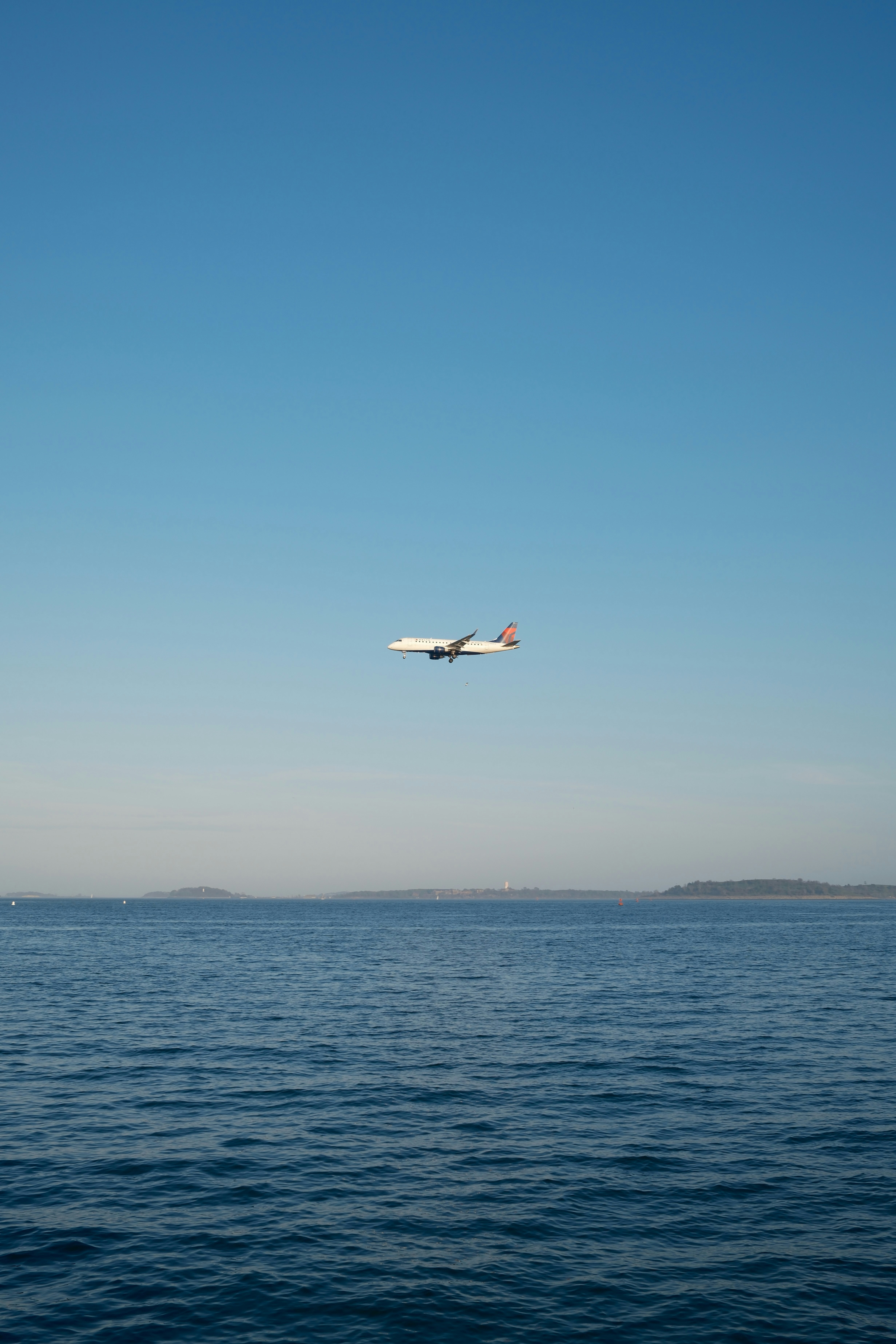 Midair Over a Quiet Horizon: A lone airliner glides above the blue expanse