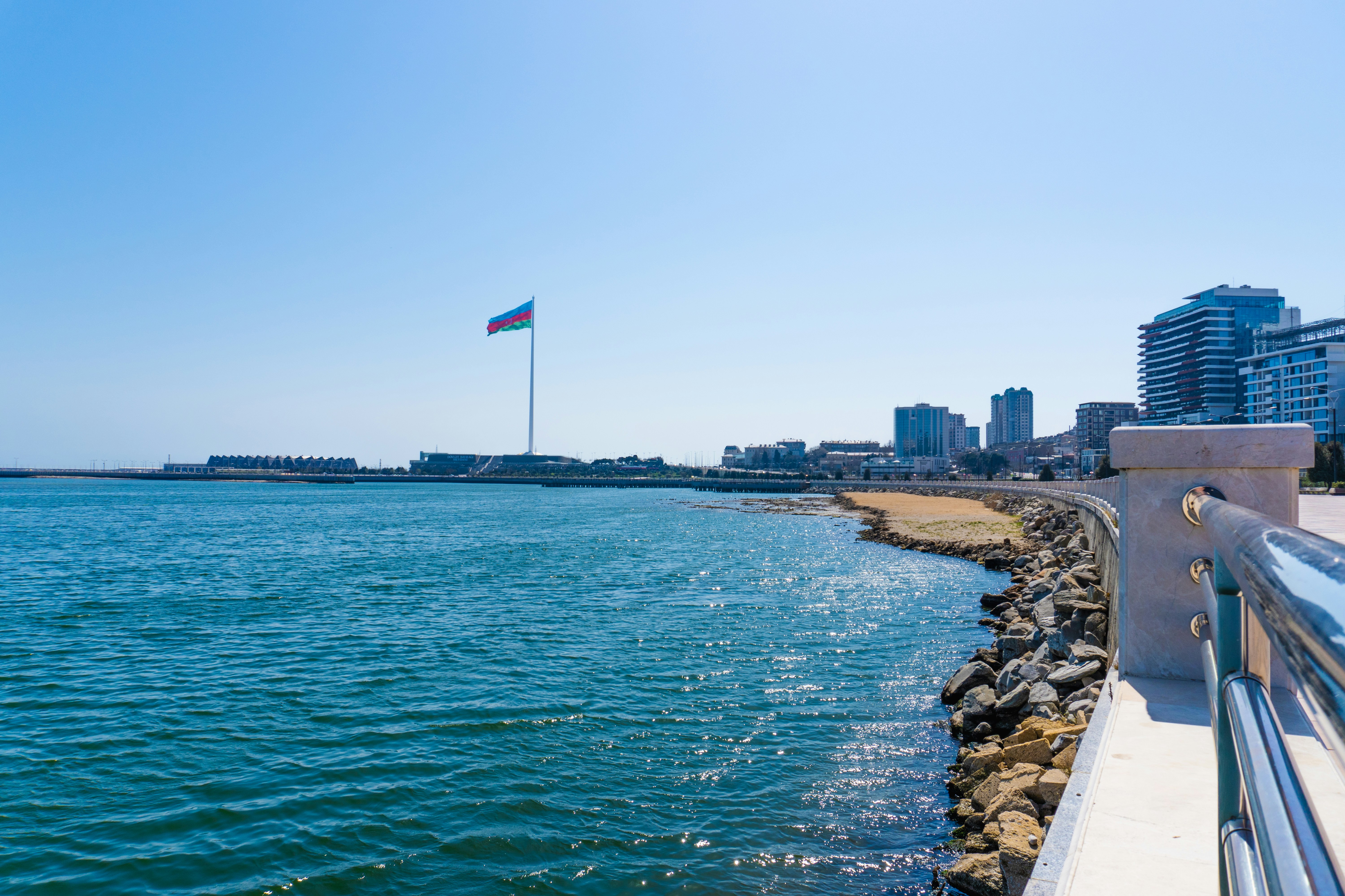 A scenic waterfront with a cityscape and flag. photo – Free Travel ...