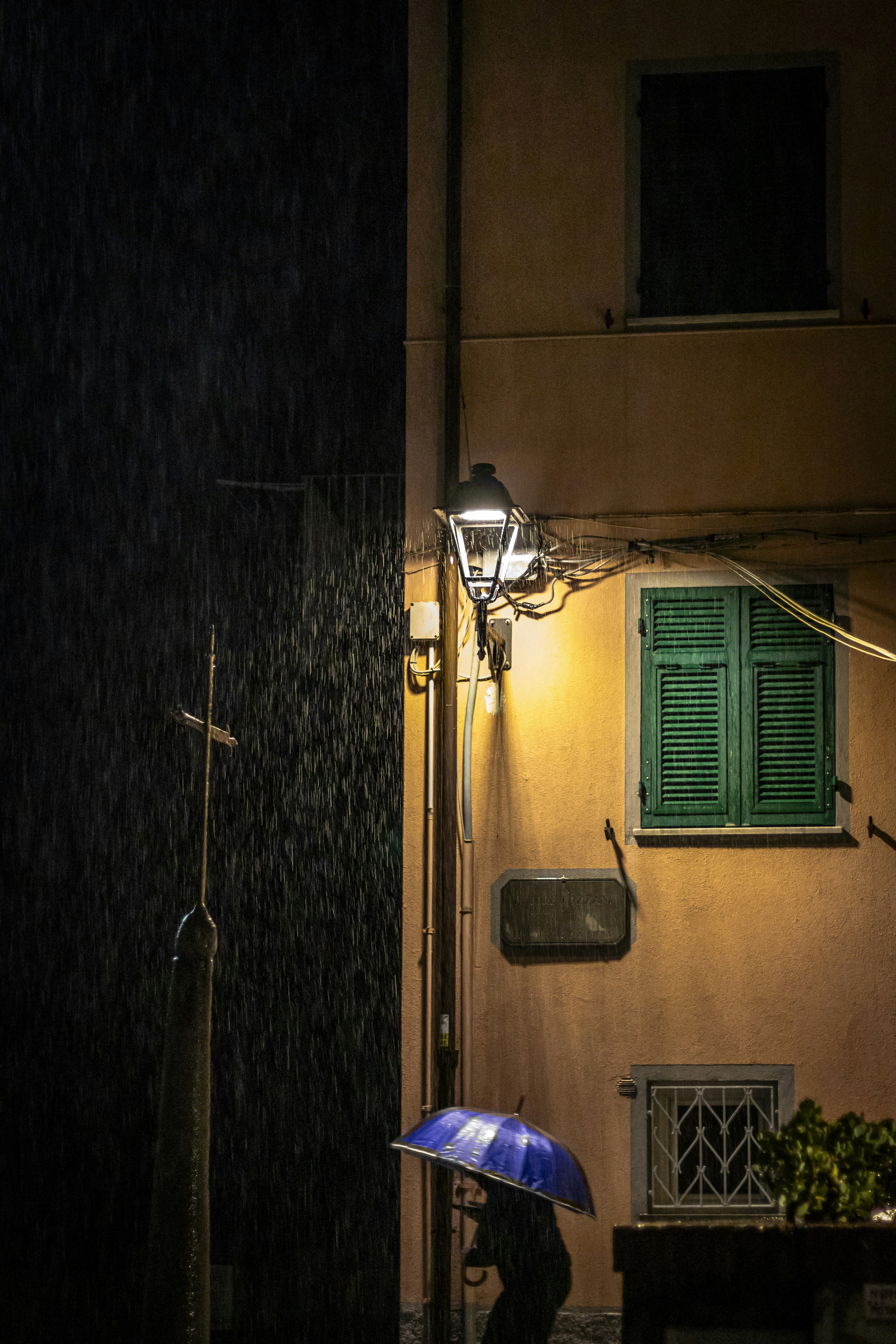 The Exorcist - Manarola, Cinque Terre - Italie 🇮🇹 | A person walks in the rain under street lights.