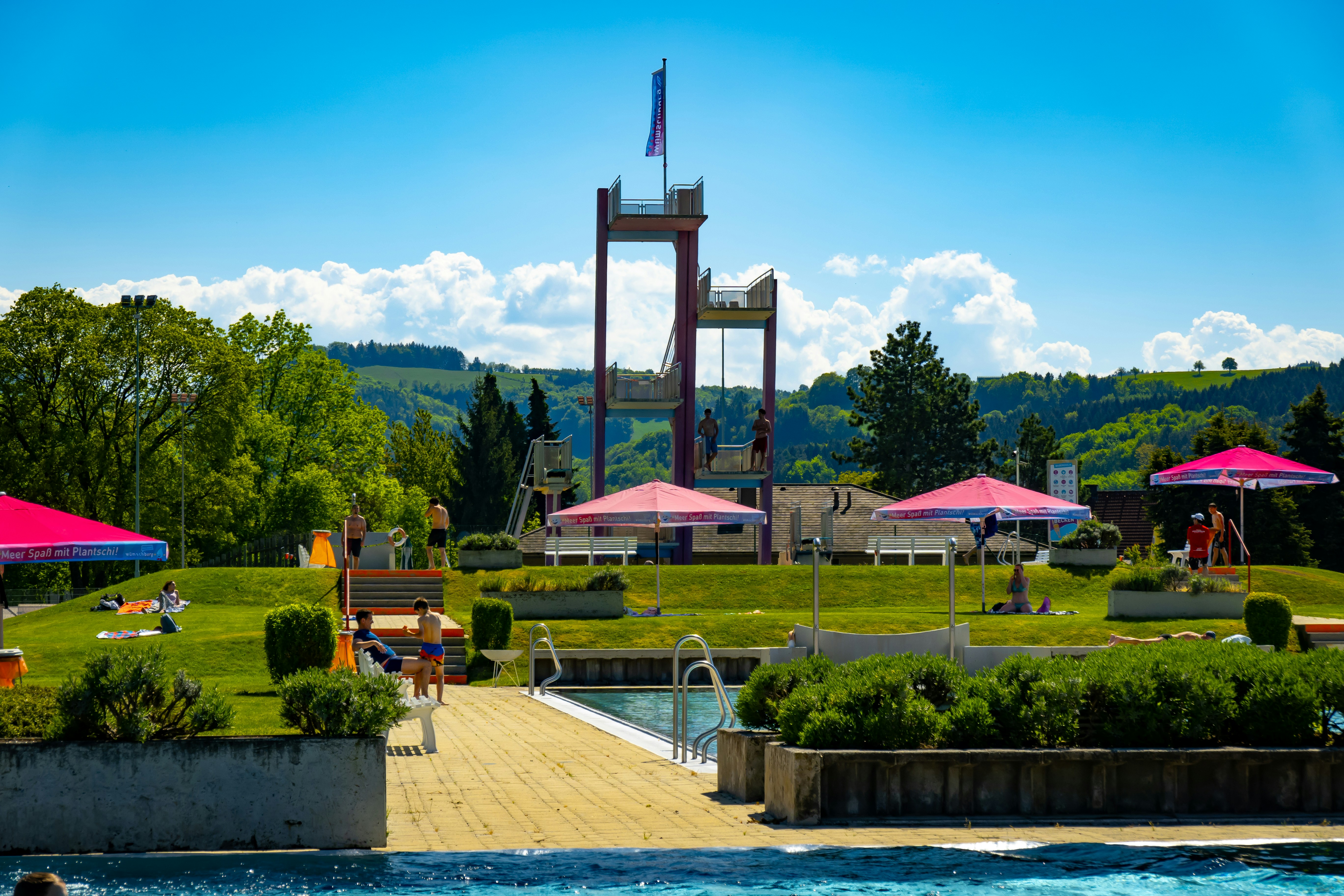 Lifeguarded Terrace by a Sunny Pool Under a Flag-topped Tower