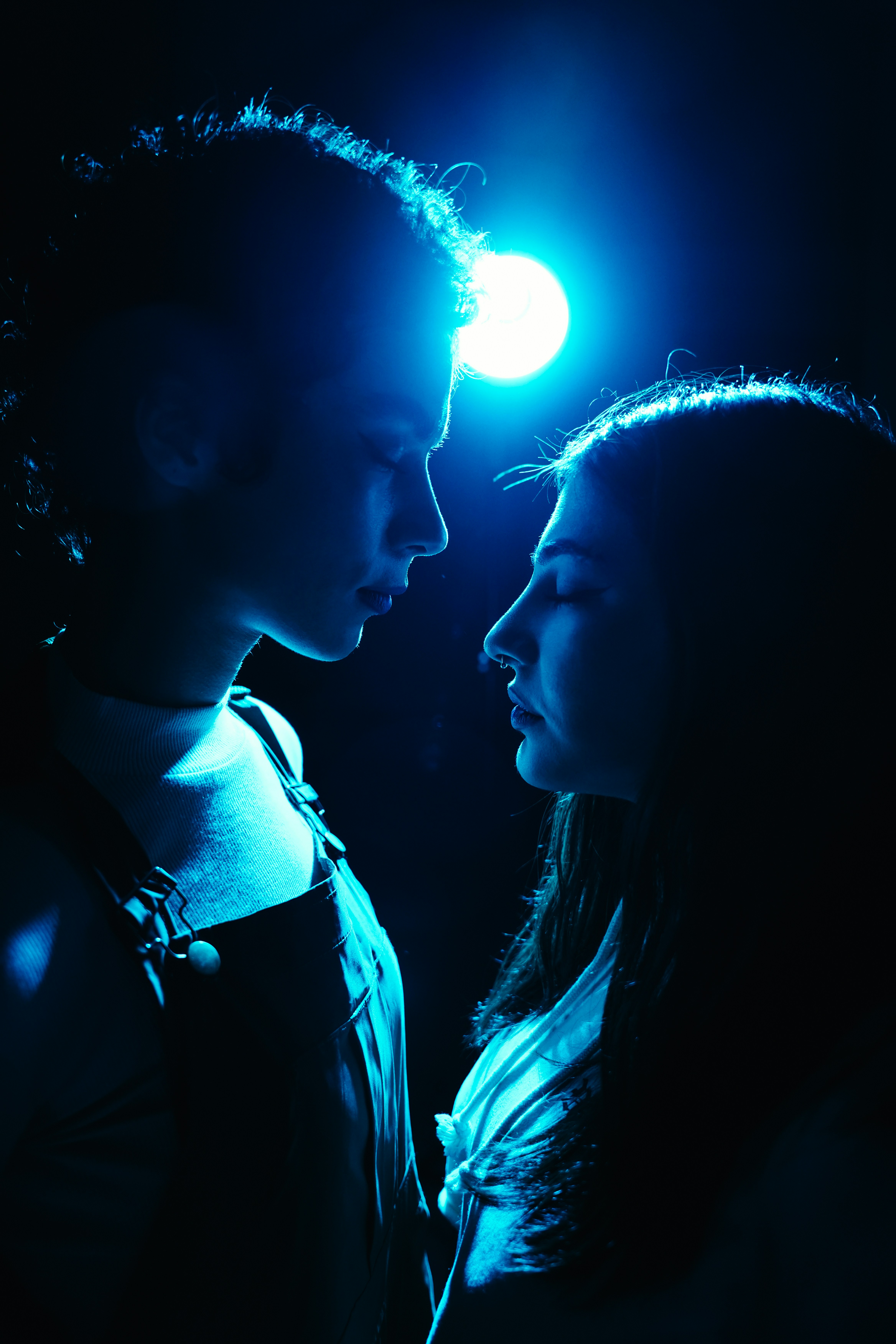 Two people face each other under dramatic blue light. photo – Free ...