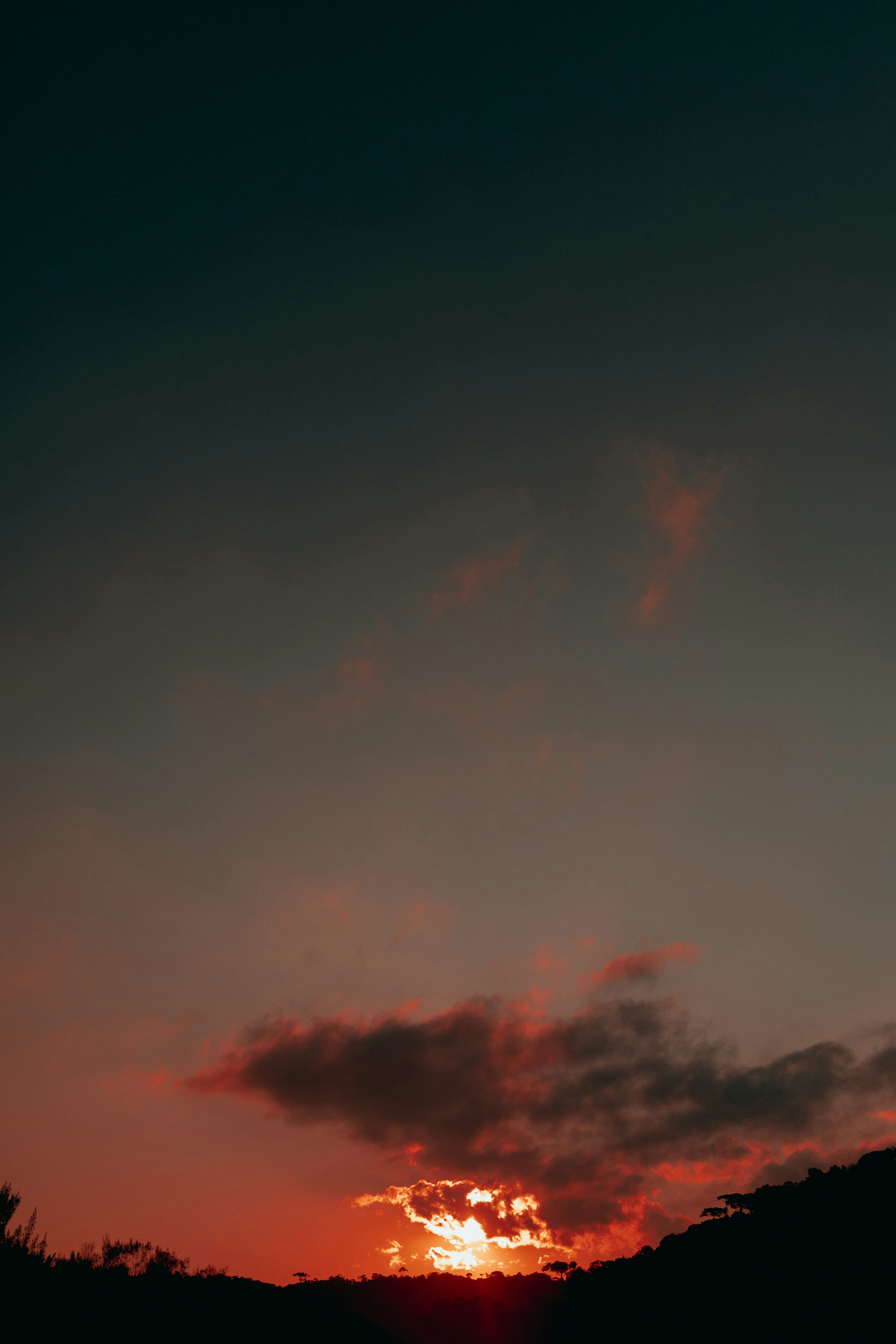 Sunset paints the clouds a fiery orange.
