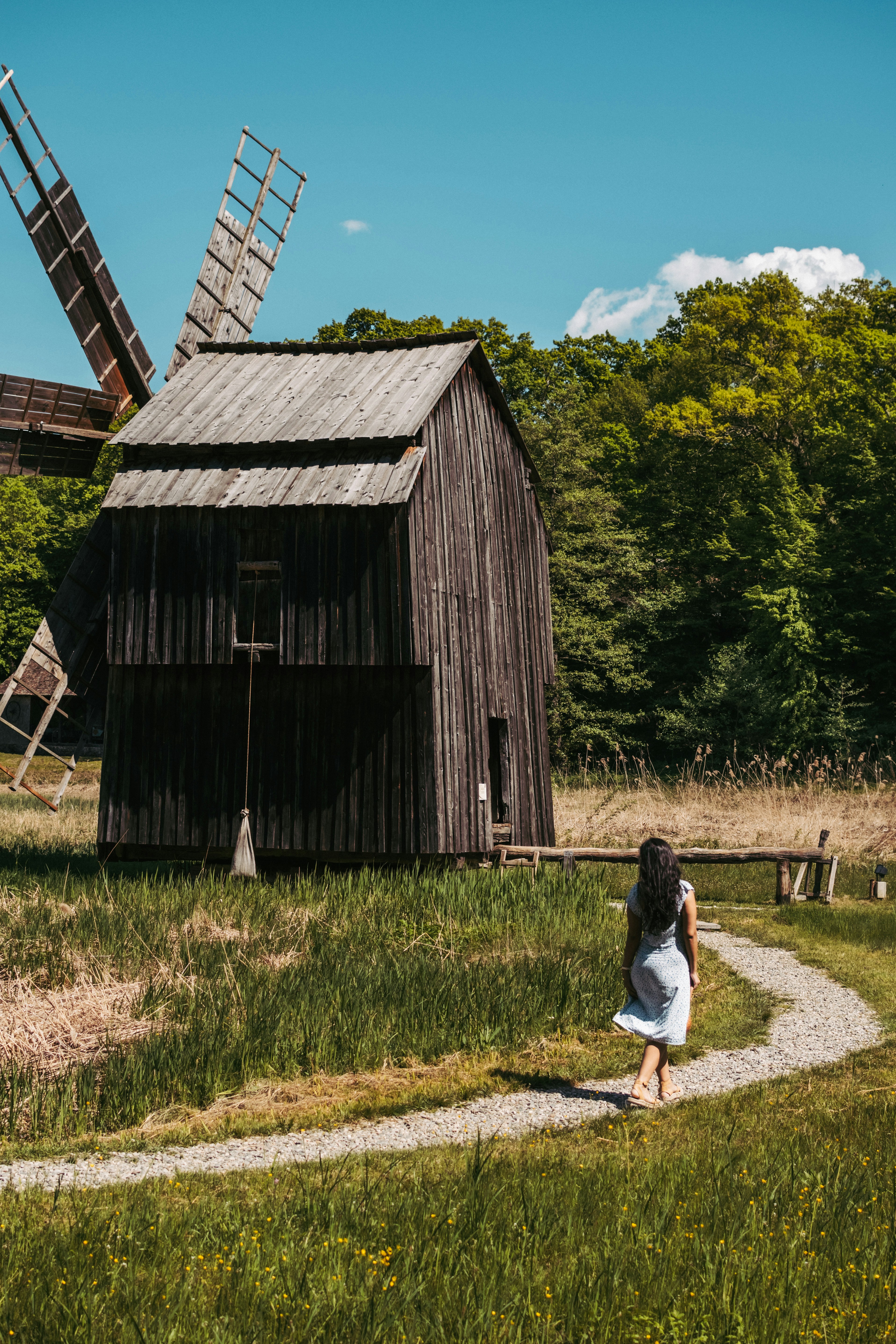 Sunlit Path to a Weathered Windmill: A Girl Walks Toward the Past