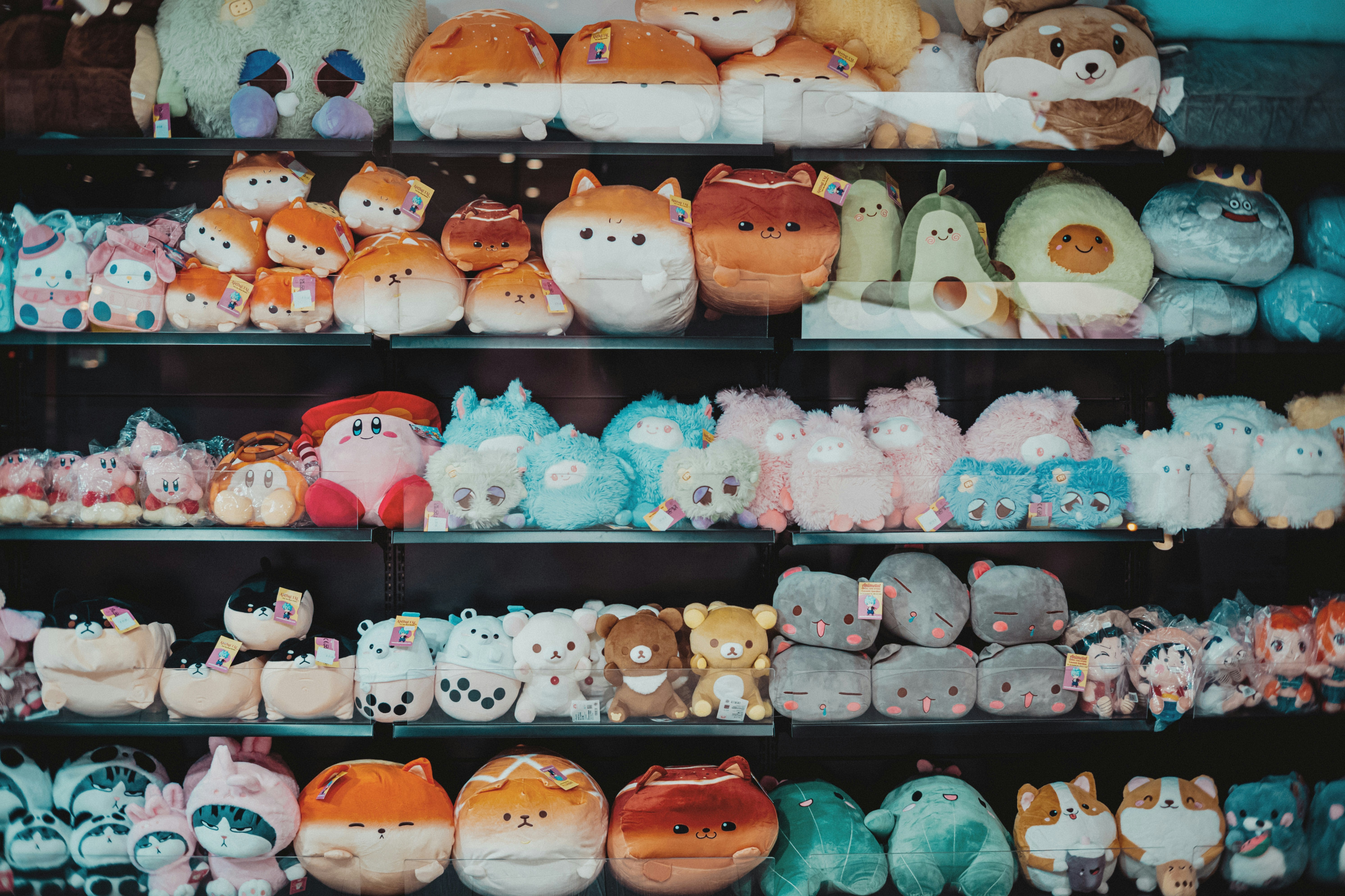 A vibrant display of assorted plush toys arranged on shelves, featuring various adorable characters in soft pastel colors.