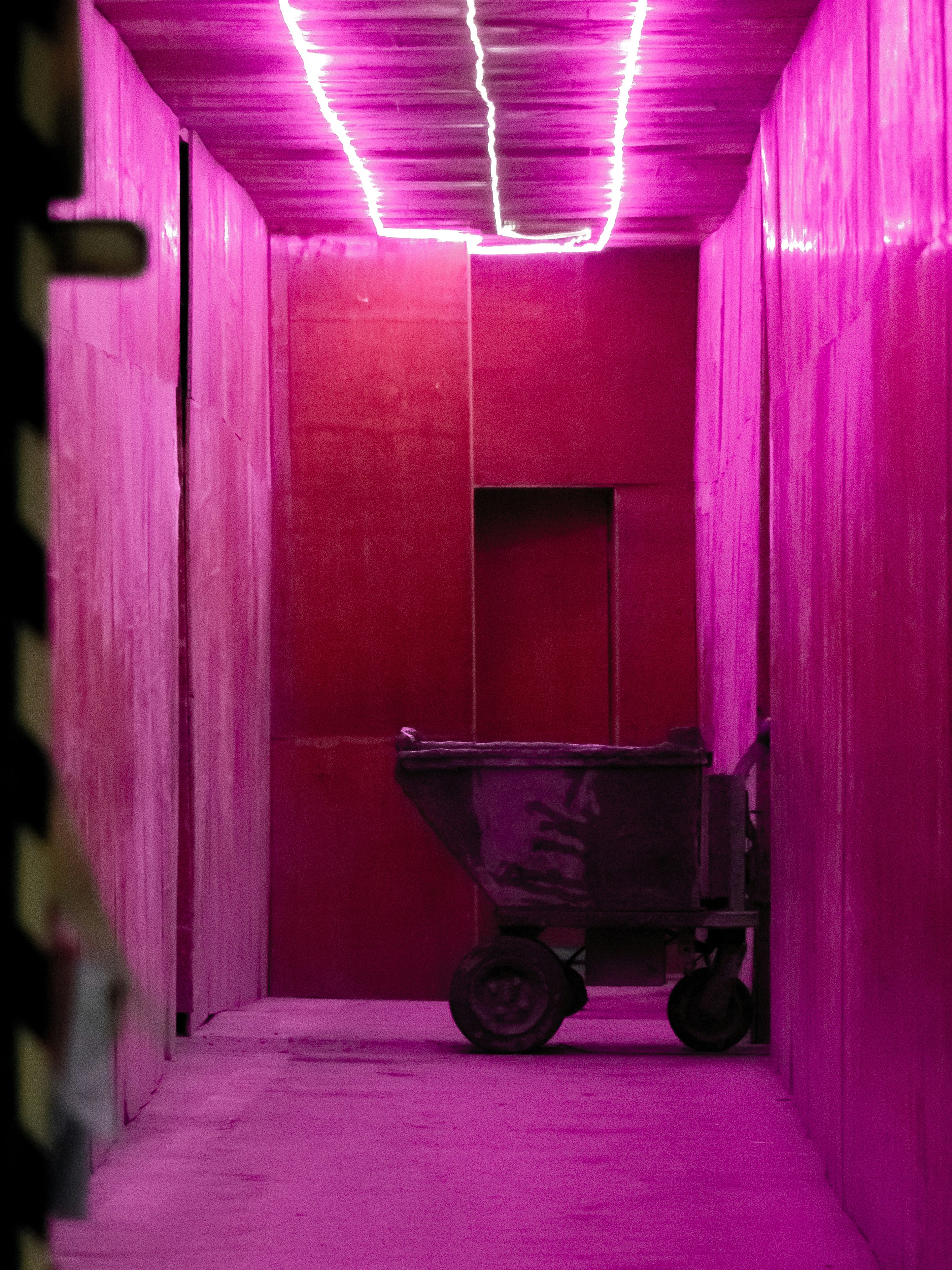 Neon Corridor: Magenta-lit Hallway and the Weathered Dump Cart