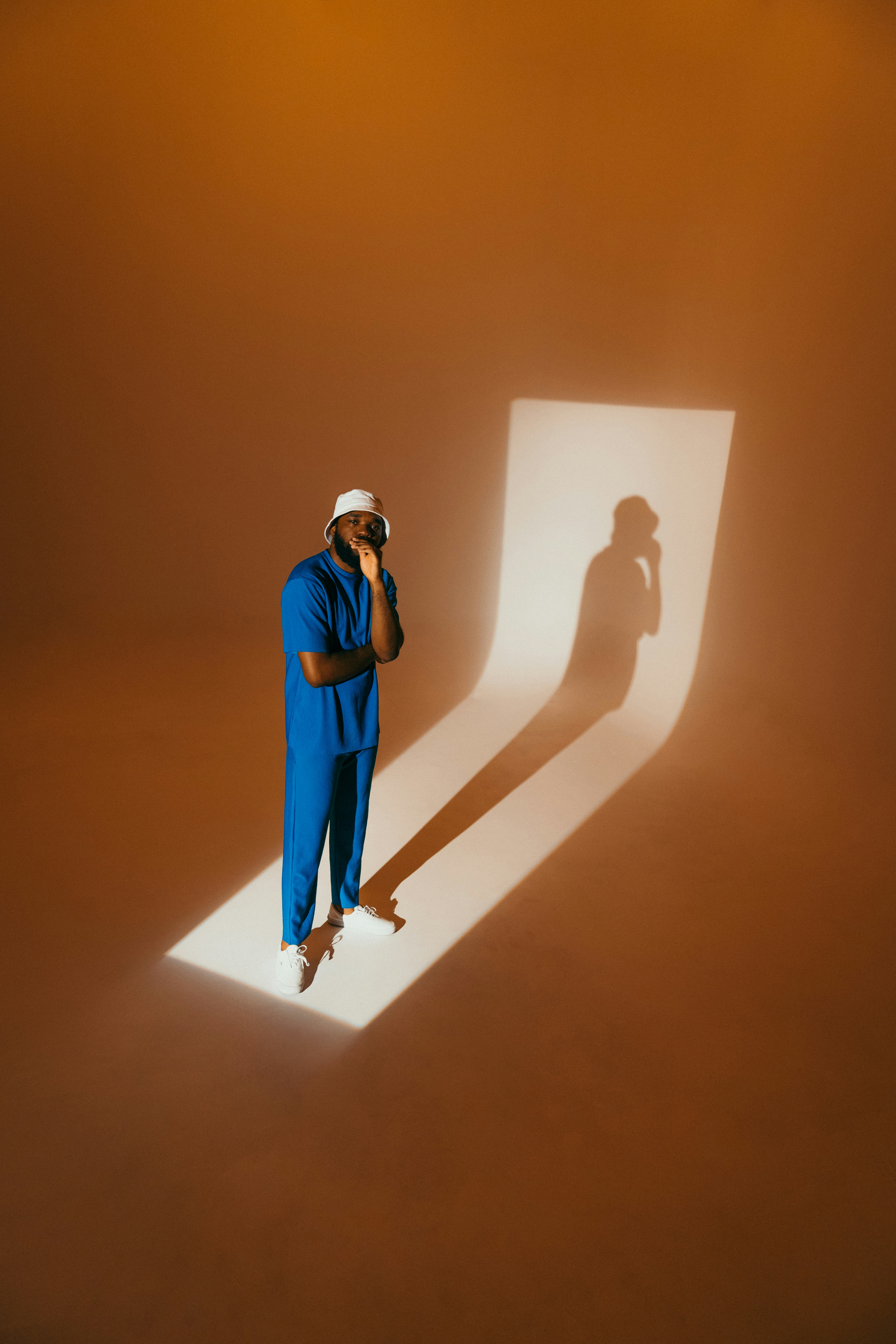 A man in blue casting a long shadow. photo – Free Abstract Image on ...