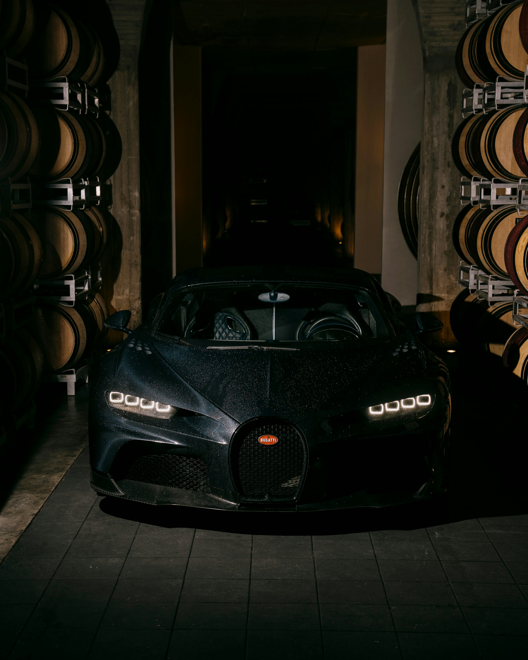 A bugatti chiron sits in a dark wine cellar. photo – Free Image on Unsplash