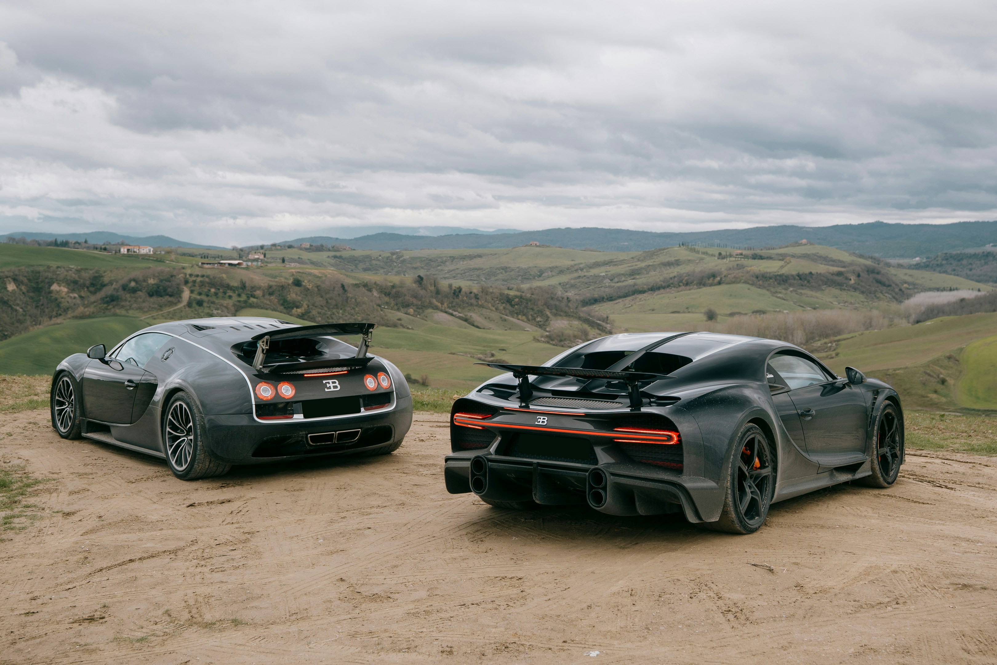 Deux voitures Bugatti sont posées au sommet d’une colline. photo ...