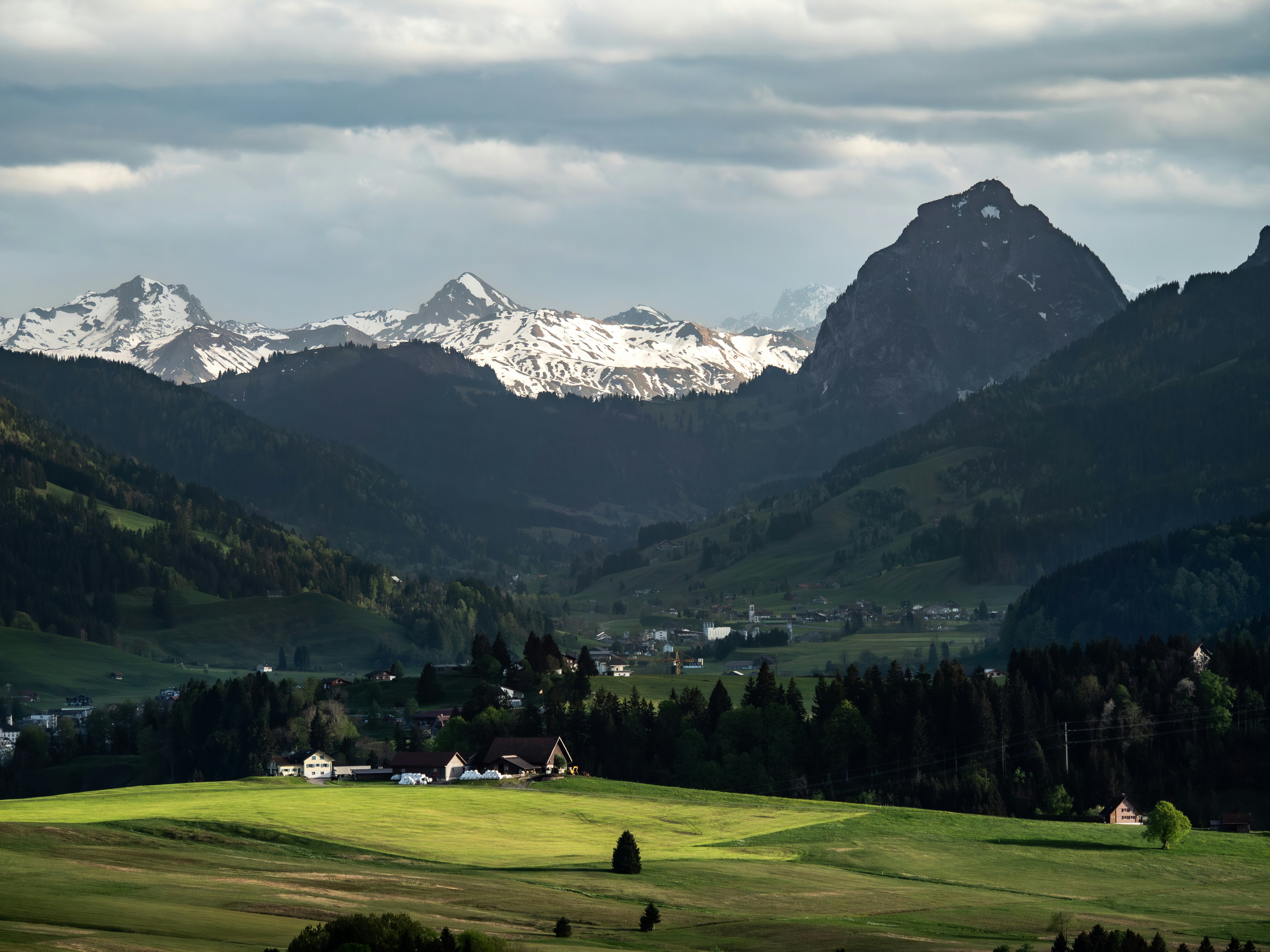 Mountains rise above a valley and small town. photo – Free Spring Image ...