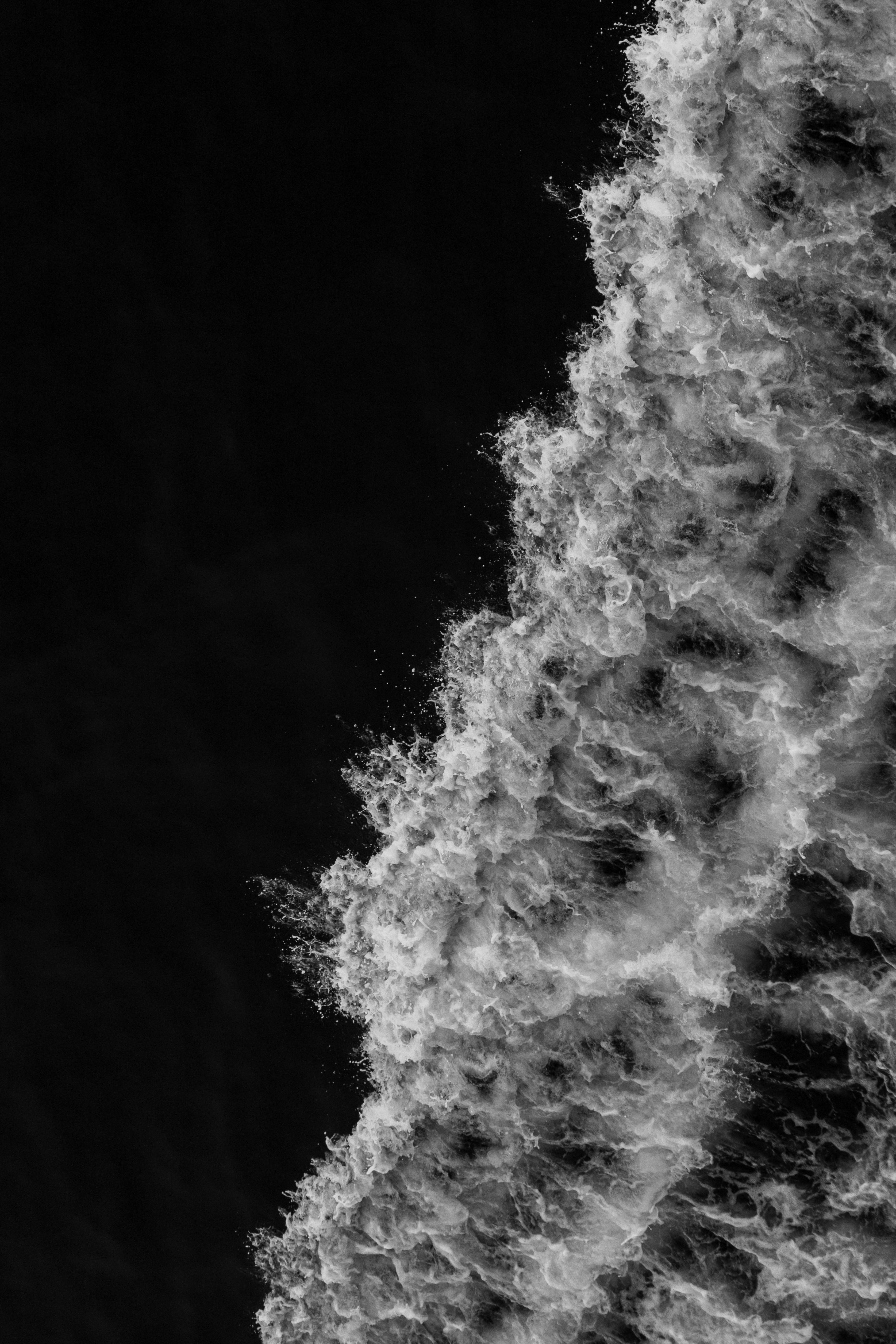 Dynamic whitewater cresting against a dark backdrop, illustrating the powerful movement of the ocean's surface.