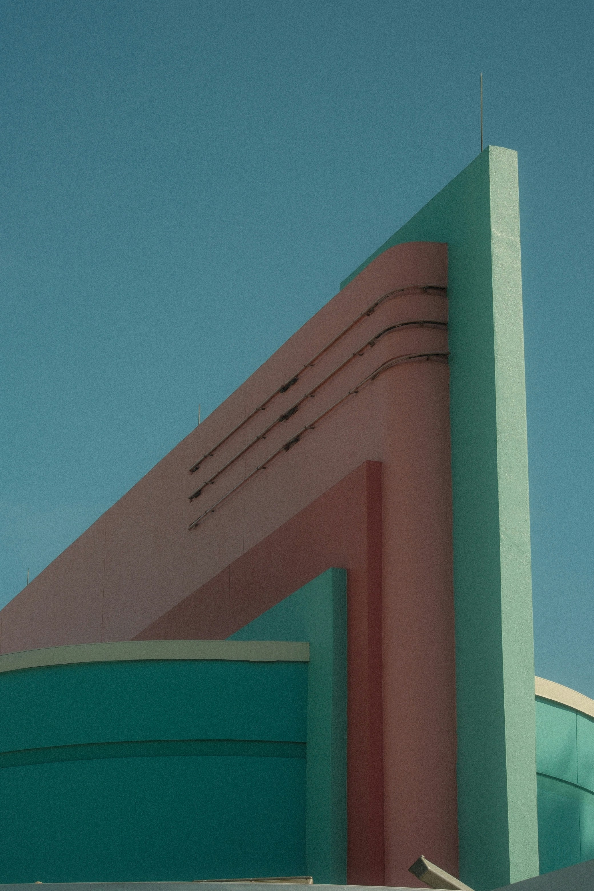 Abstract architectural details featuring pastel colors and geometric lines against a clear sky.