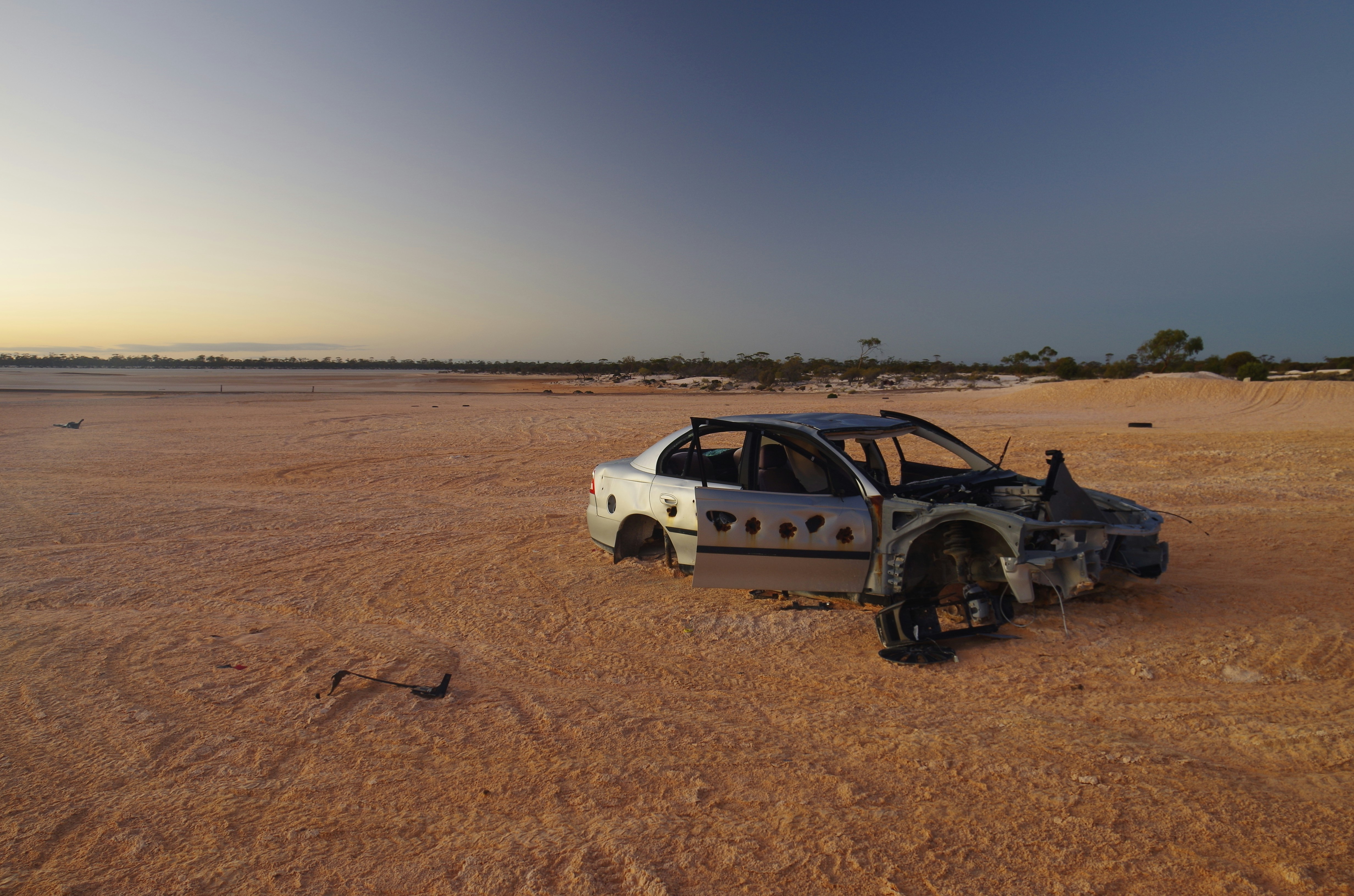 A wrecked car sits alone in a barren landscape. photo – Free Car Image ...