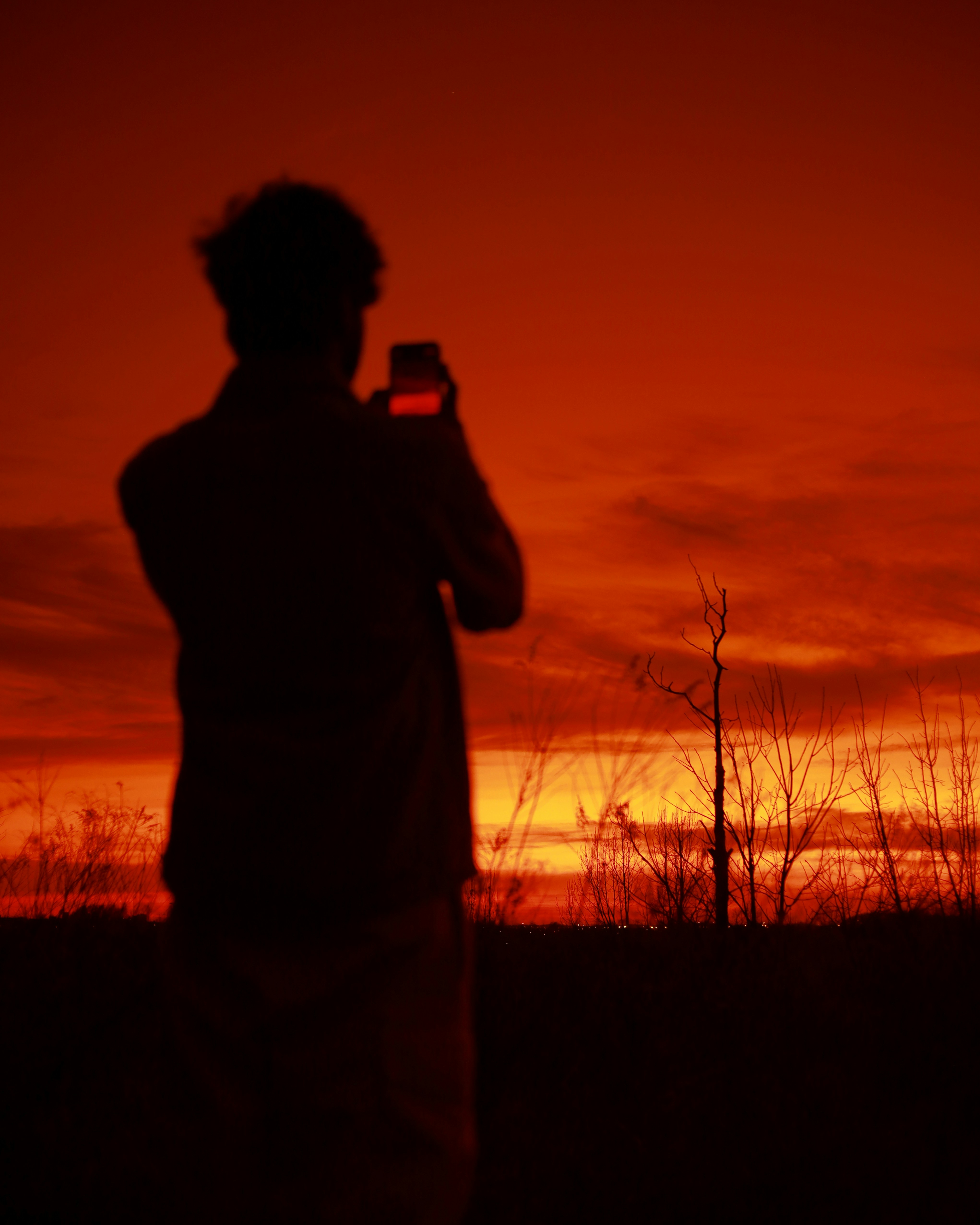 Scarlet Horizon Silhouette: A Photographer Seizing Sunset on Mobile