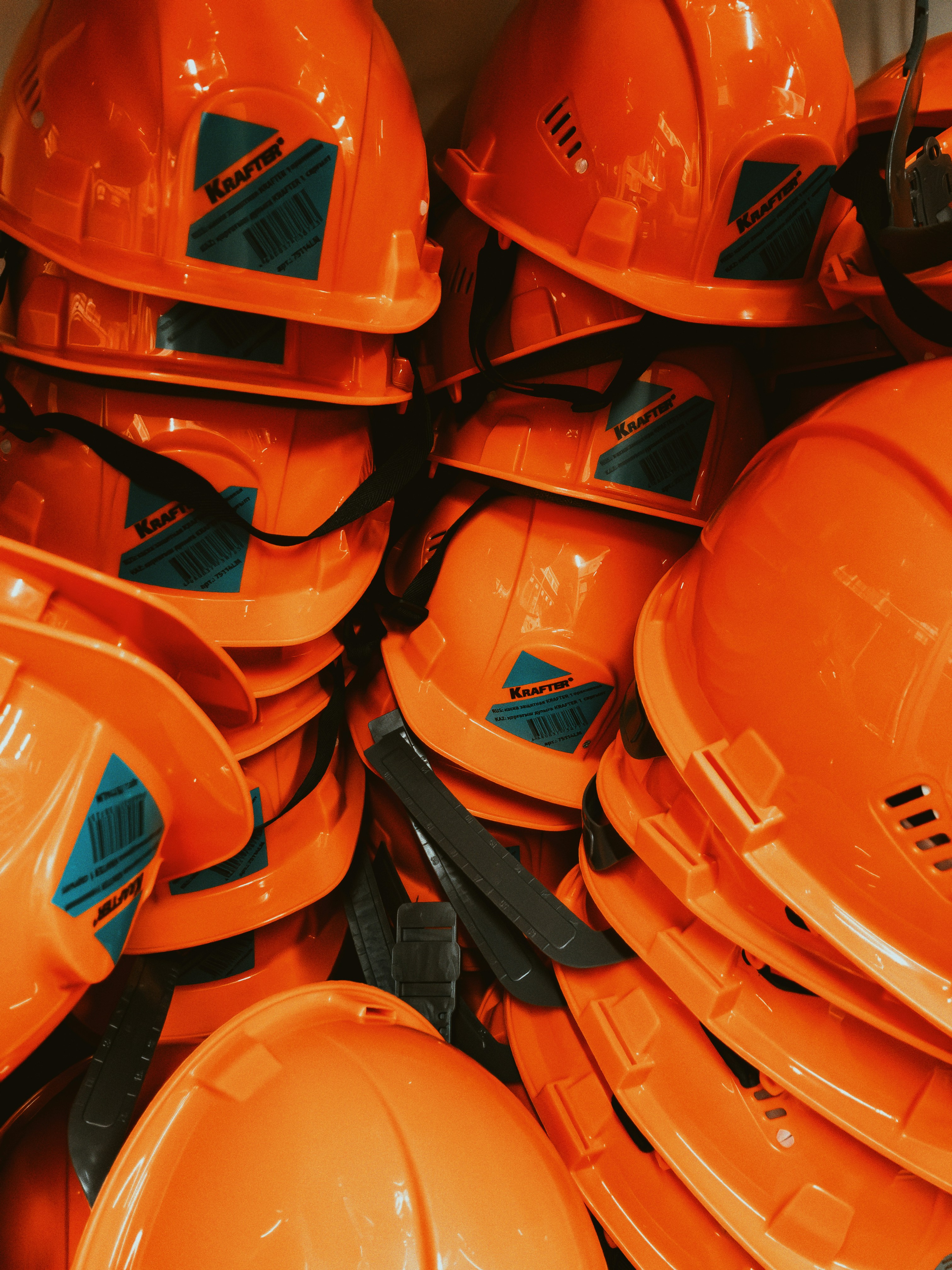 Stacked Orange Hard Hats: A Close-Quarters Study in Safety Gear