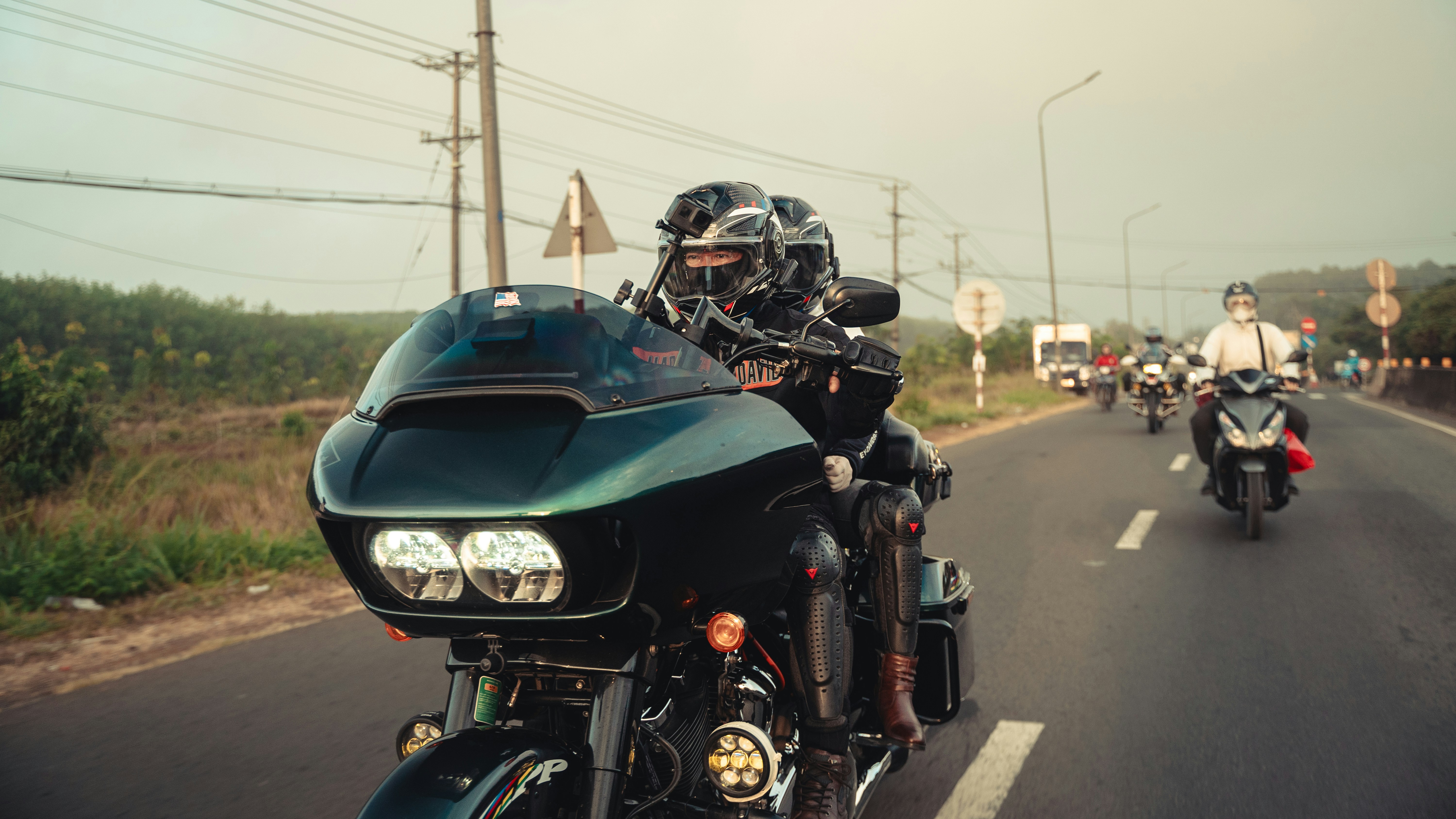 A motorcycle convoy rides down a rural road. photo – Free Image on Unsplash