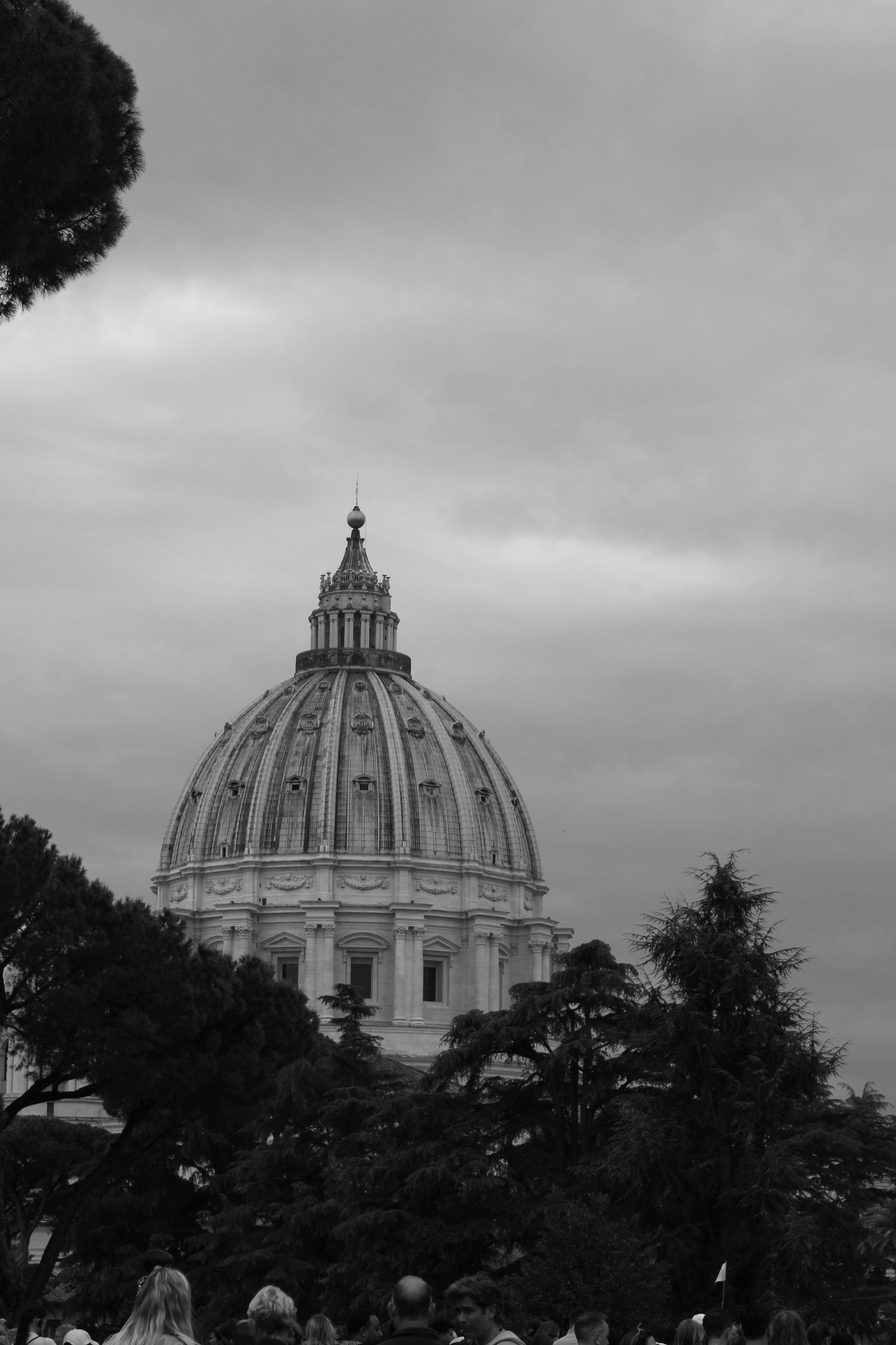 St. peter's basilica dome against a cloudy sky.