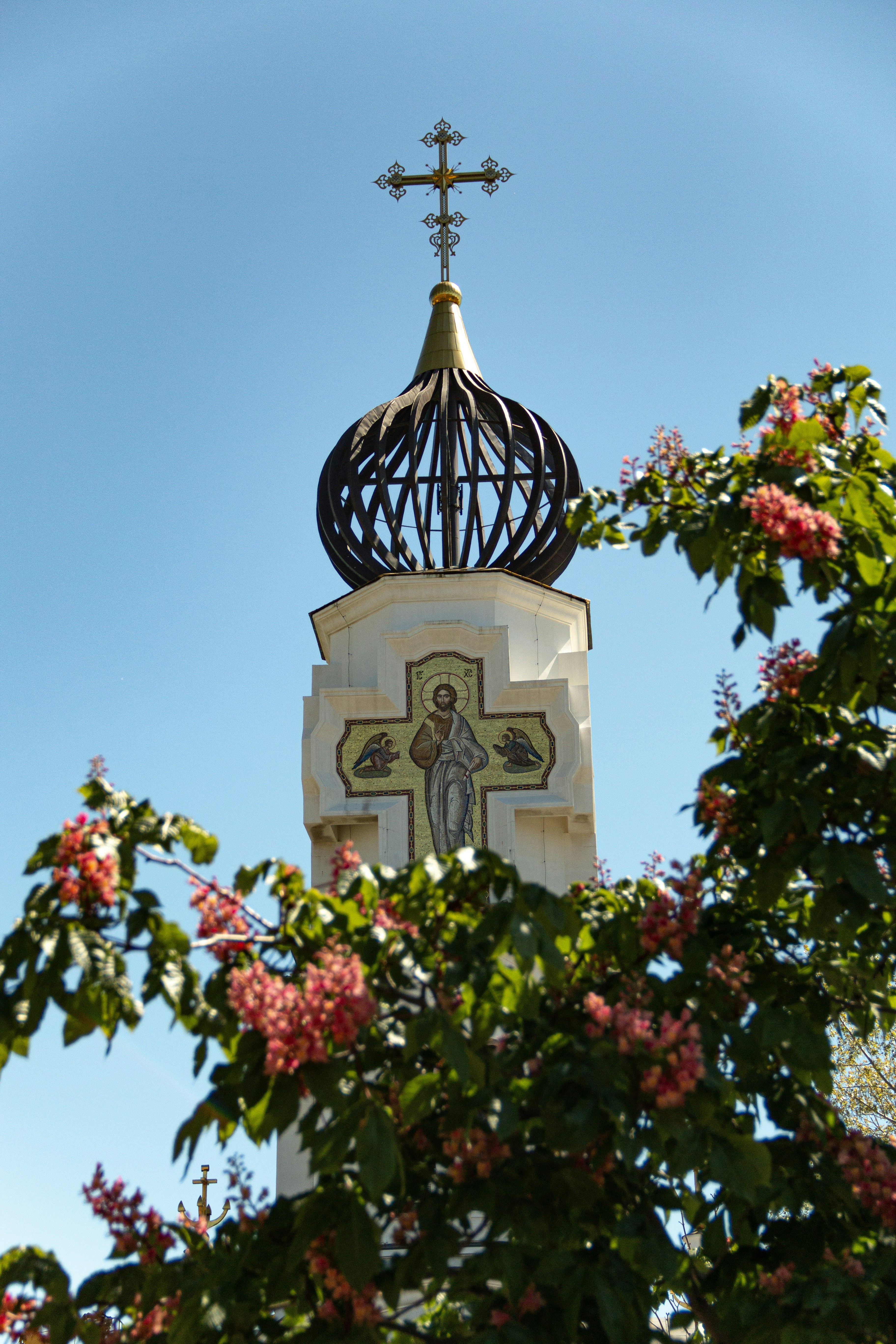 Cross Above the Lattice Dome, Framed by Spring Blooms Under a Cerulean Sky