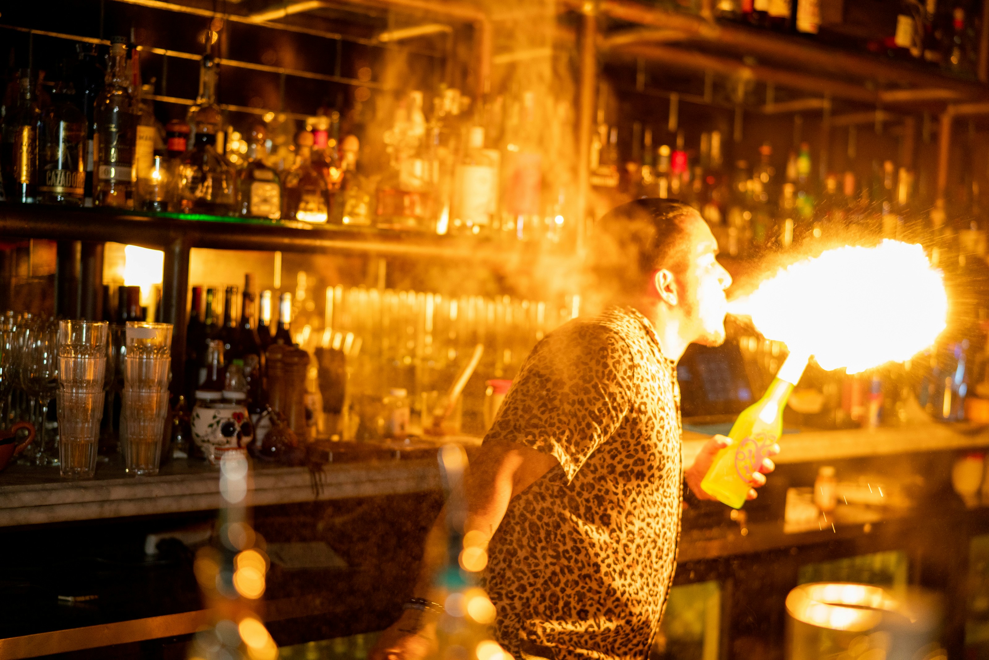 Fire-breathing bartender in a dim bar