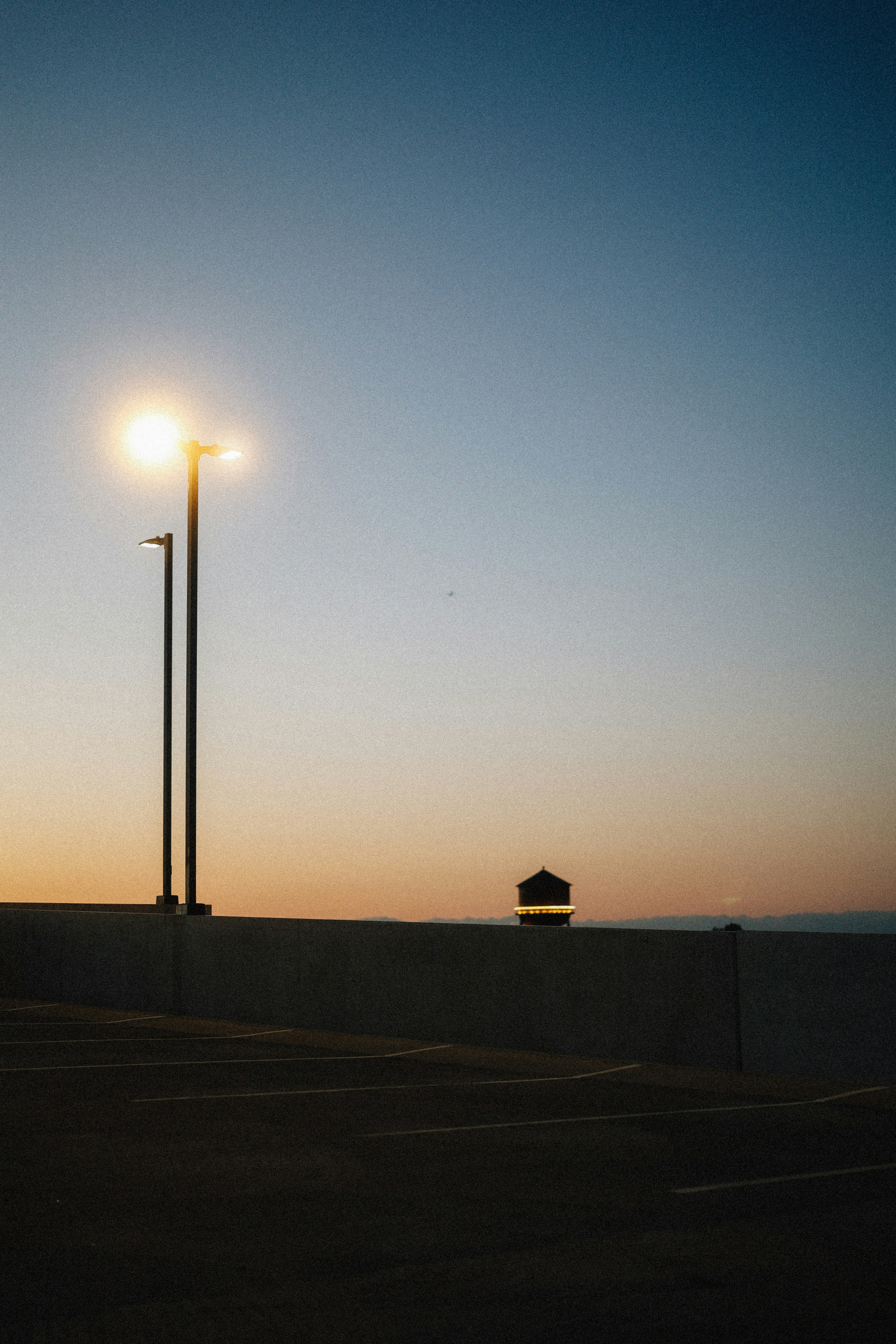 A lamp post glows against a twilight sky. photo – Free Image on Unsplash