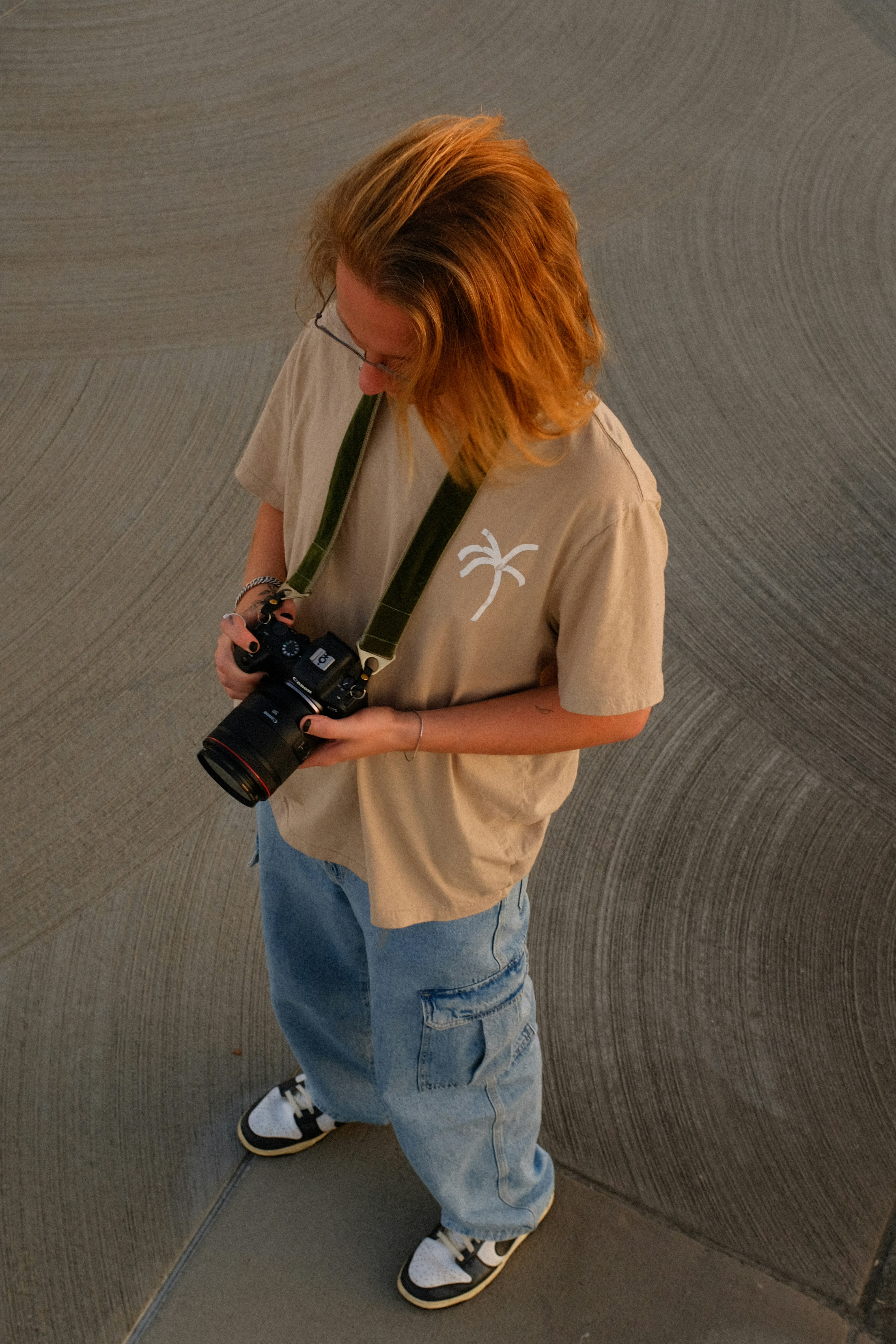 Top-Down Portrait: A Street Photographer Paused on Circular Concrete