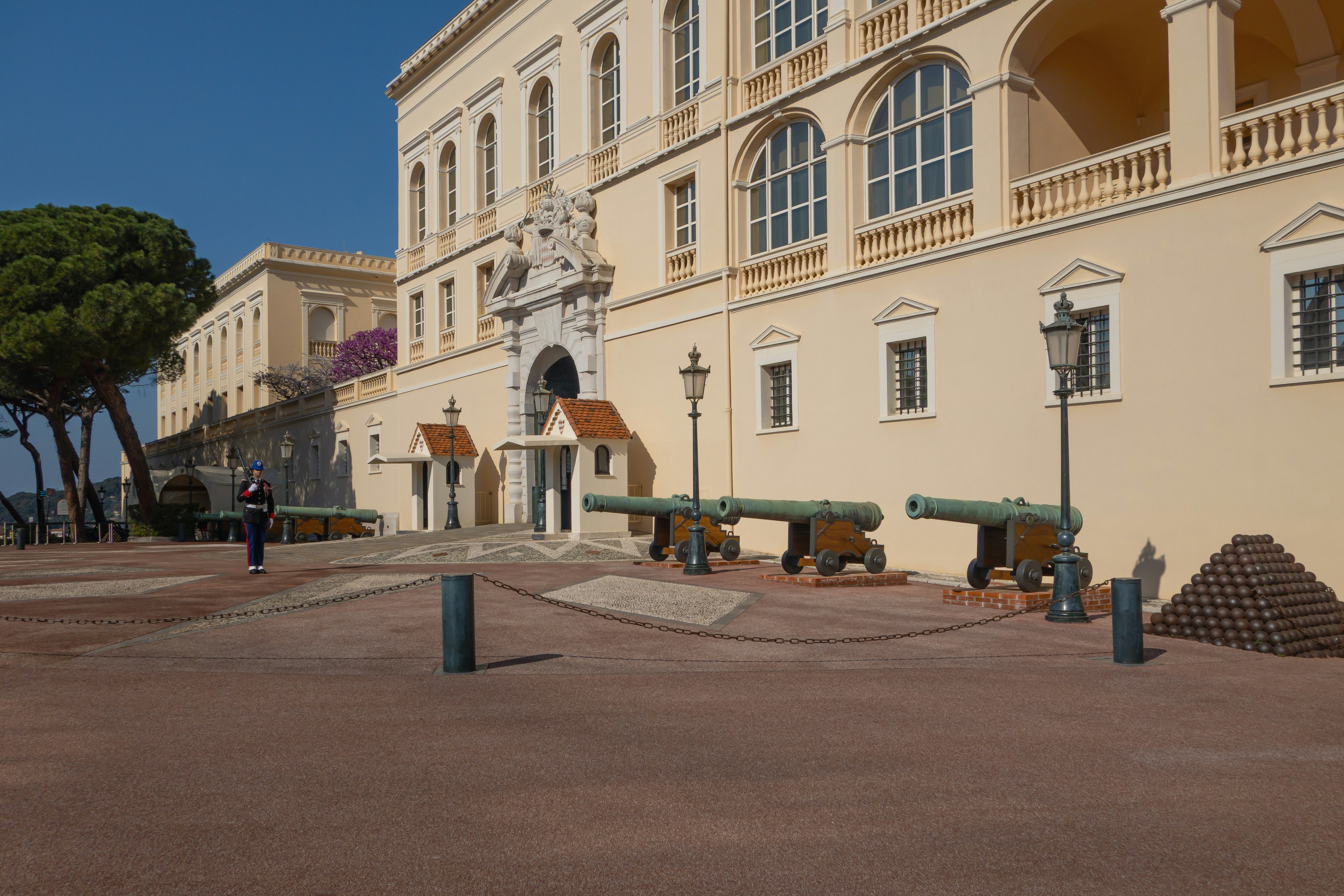 Historic coastal fortress façade with antique artillery on a sunlit terrace