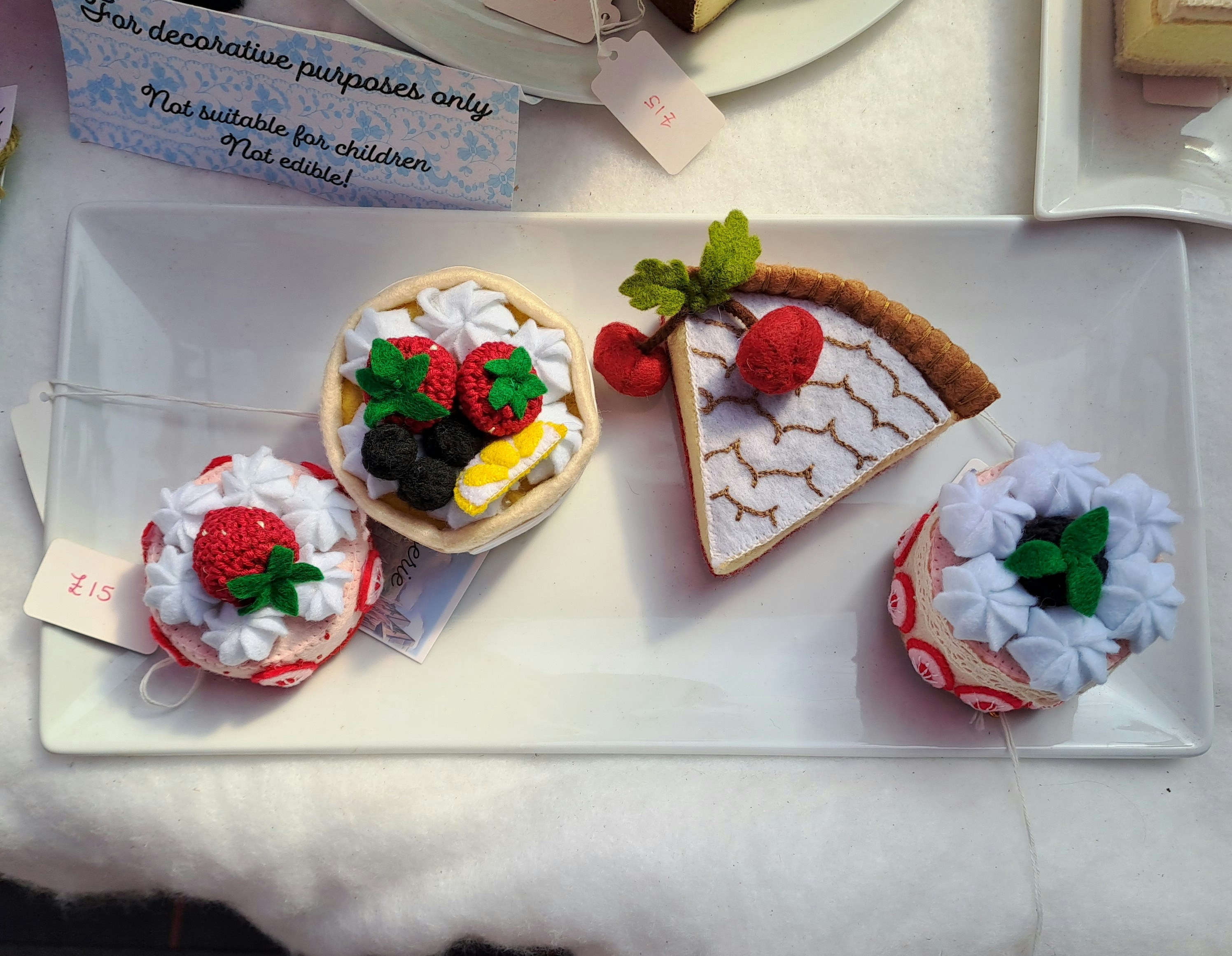 Felt desserts on a tray, decorated for christmas.