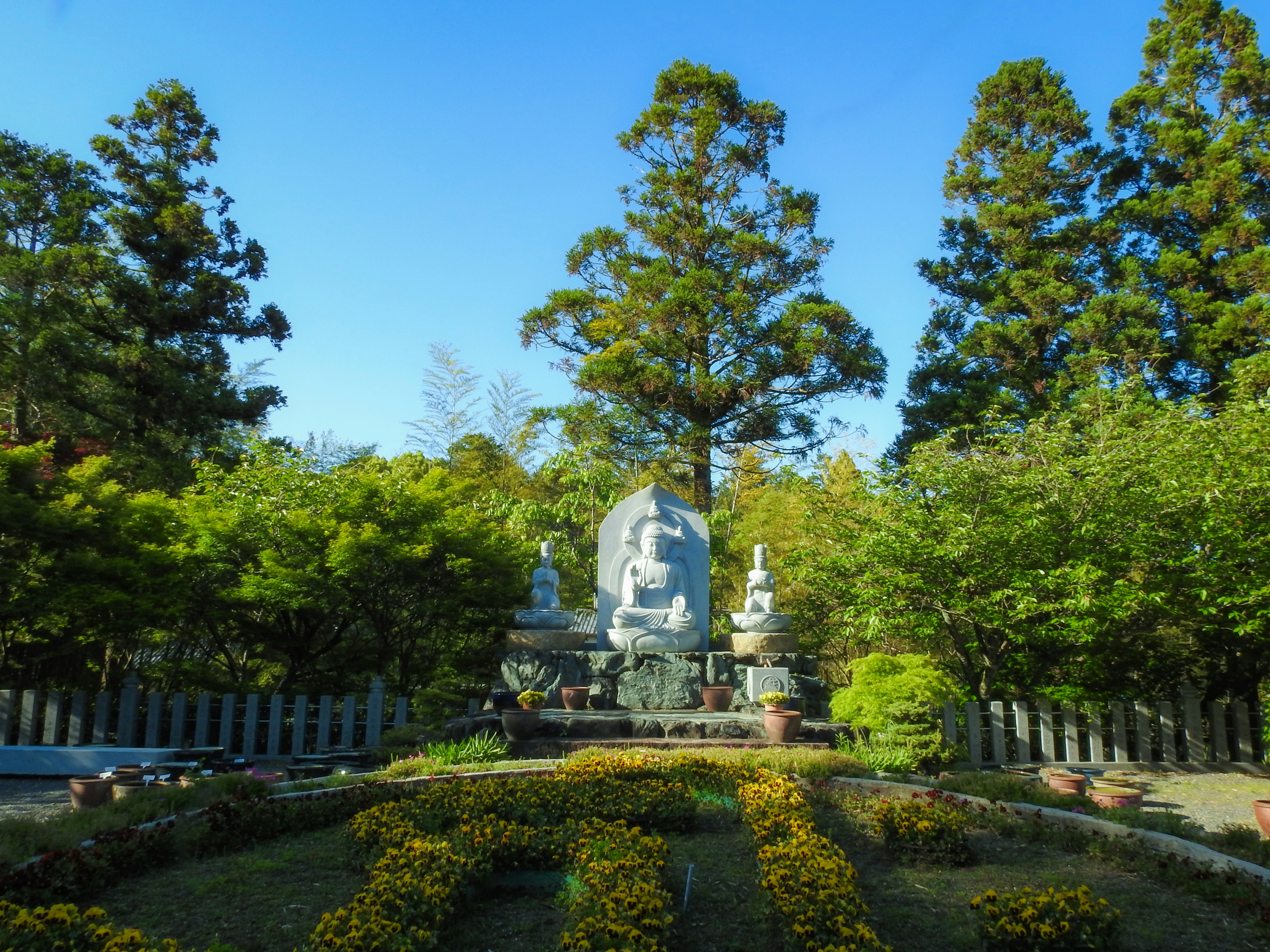 Serenity in the Green Ring: Center Statue Surrounded by Spring Blooms