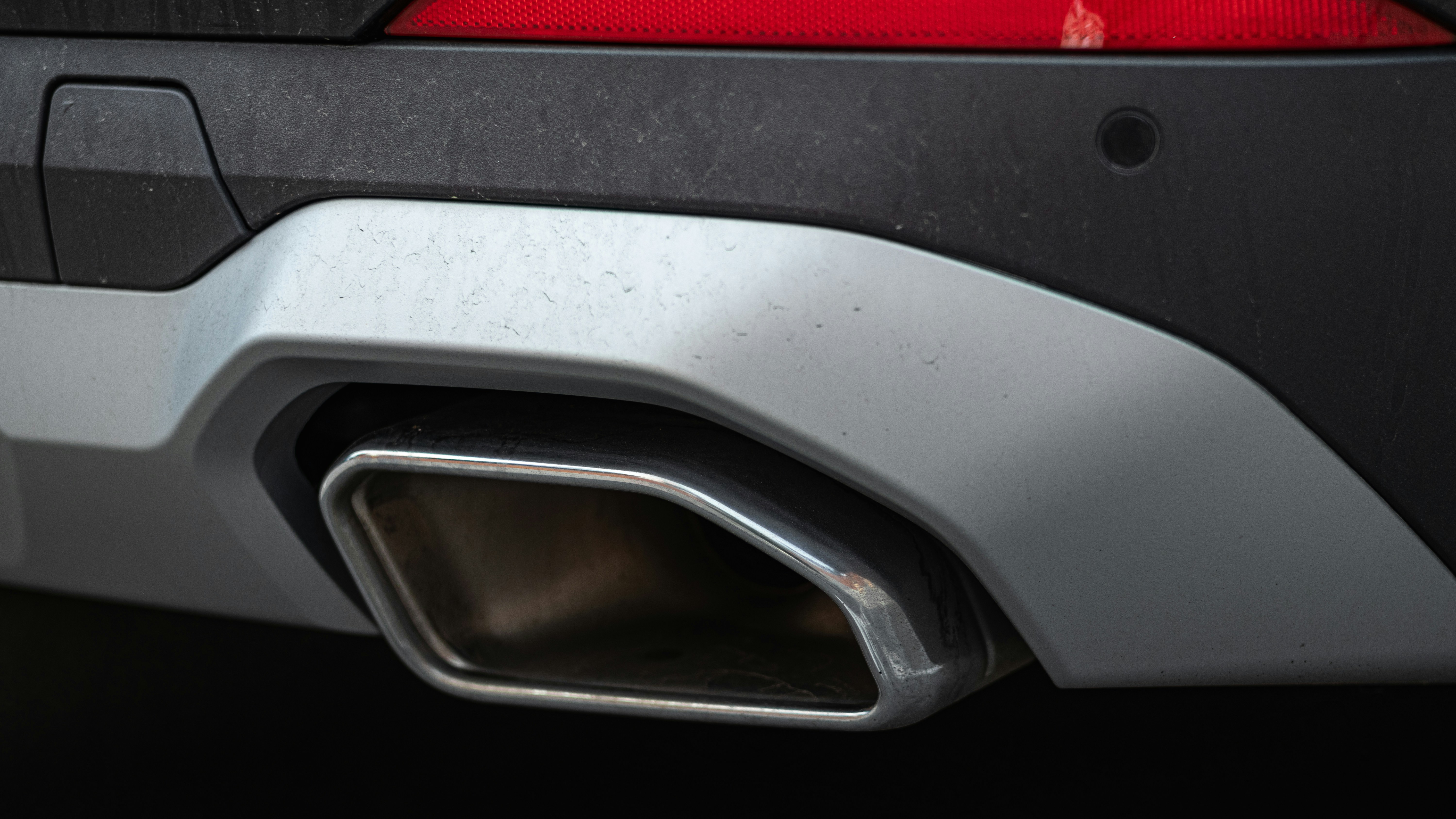 Chrome Exit: Close-Up on a Modern Car’s Rear-Bumper Exhaust