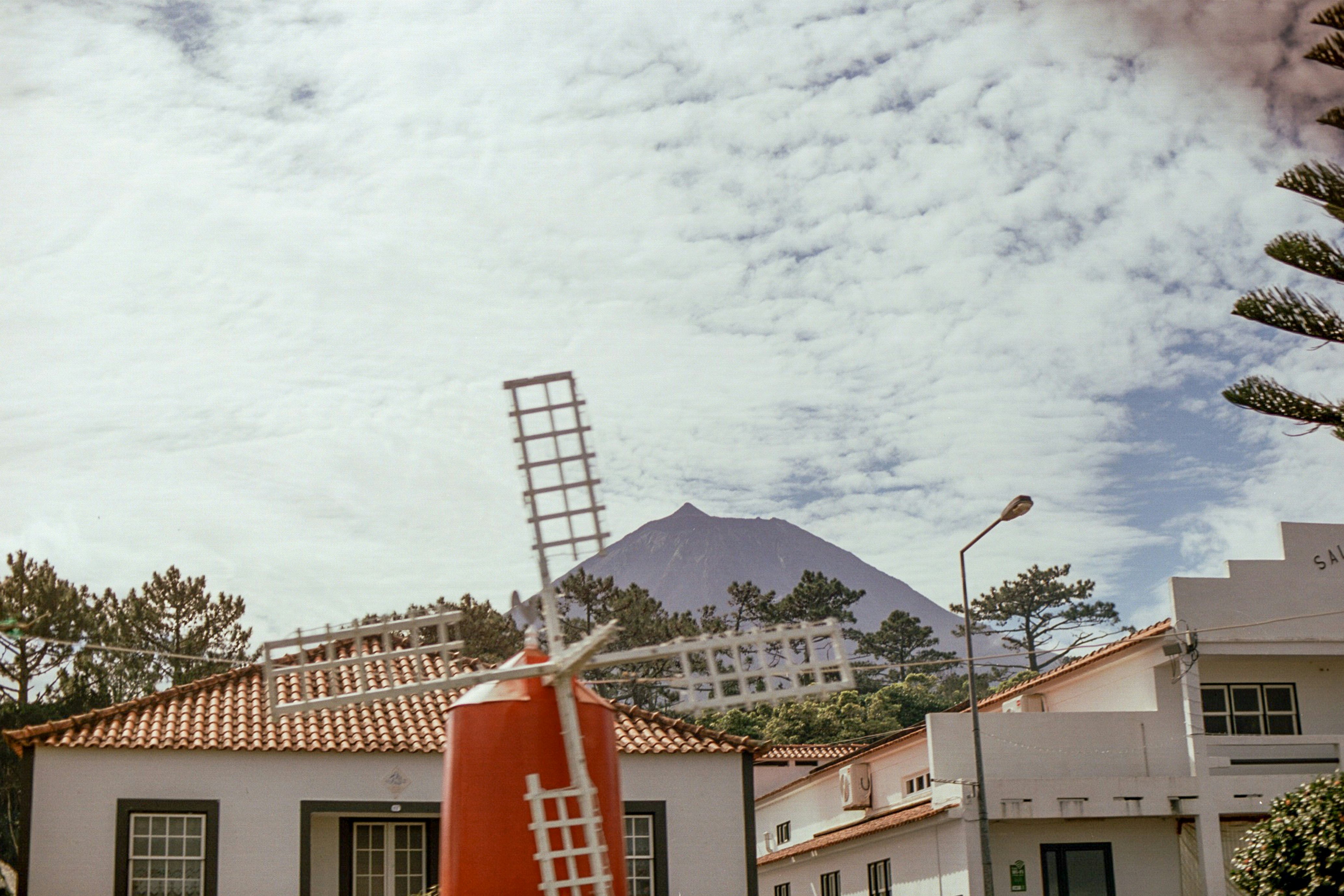 Crimson Water Tank Framing a Mountain Vista in a Sunny Suburban Scene
