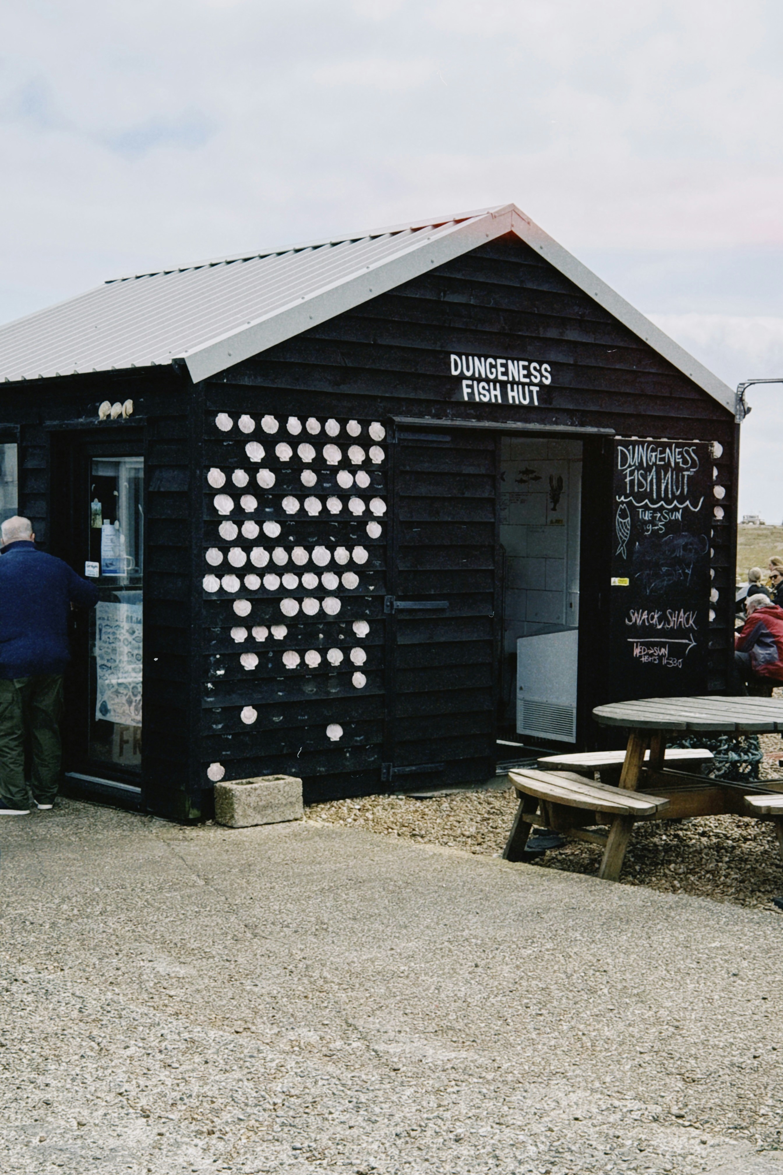 Dungeness Fish Hut: A Weathered Black Shack with Circular Wall Detail