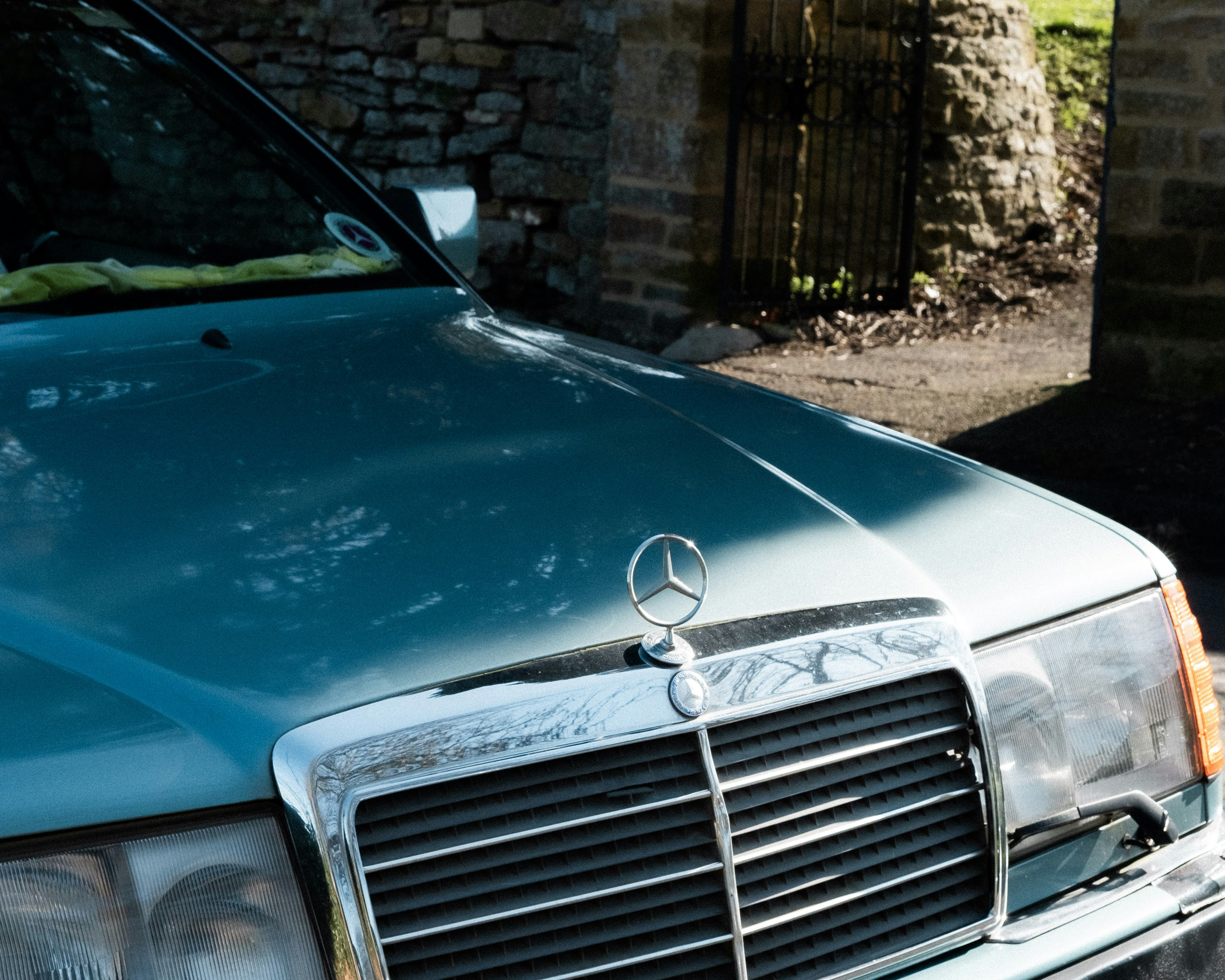 Chrome Grille Quietly Anchors a Classic Mercedes under Dappled Shade