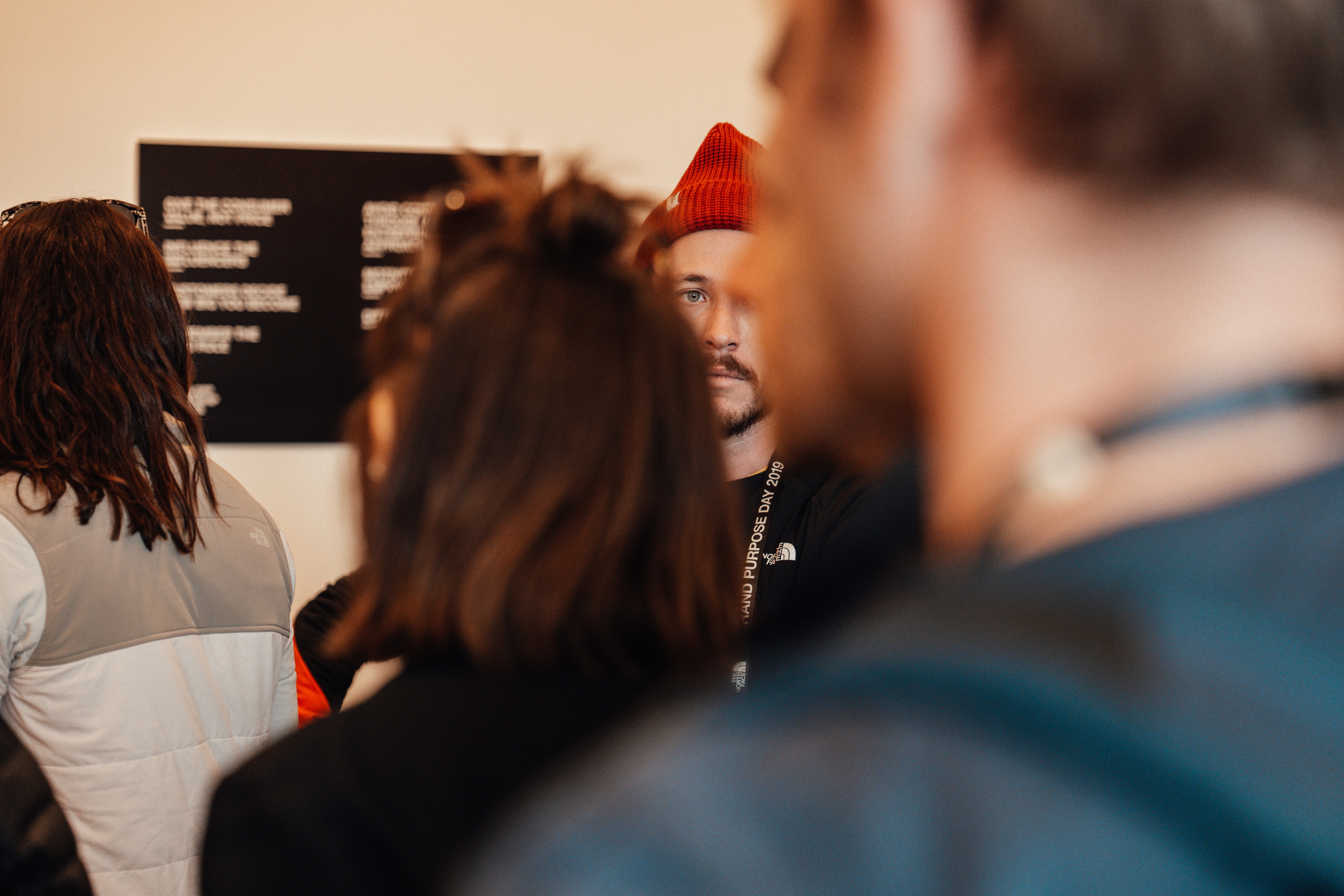 People are gathered, one wearing a red hat. photo – Free Image on Unsplash