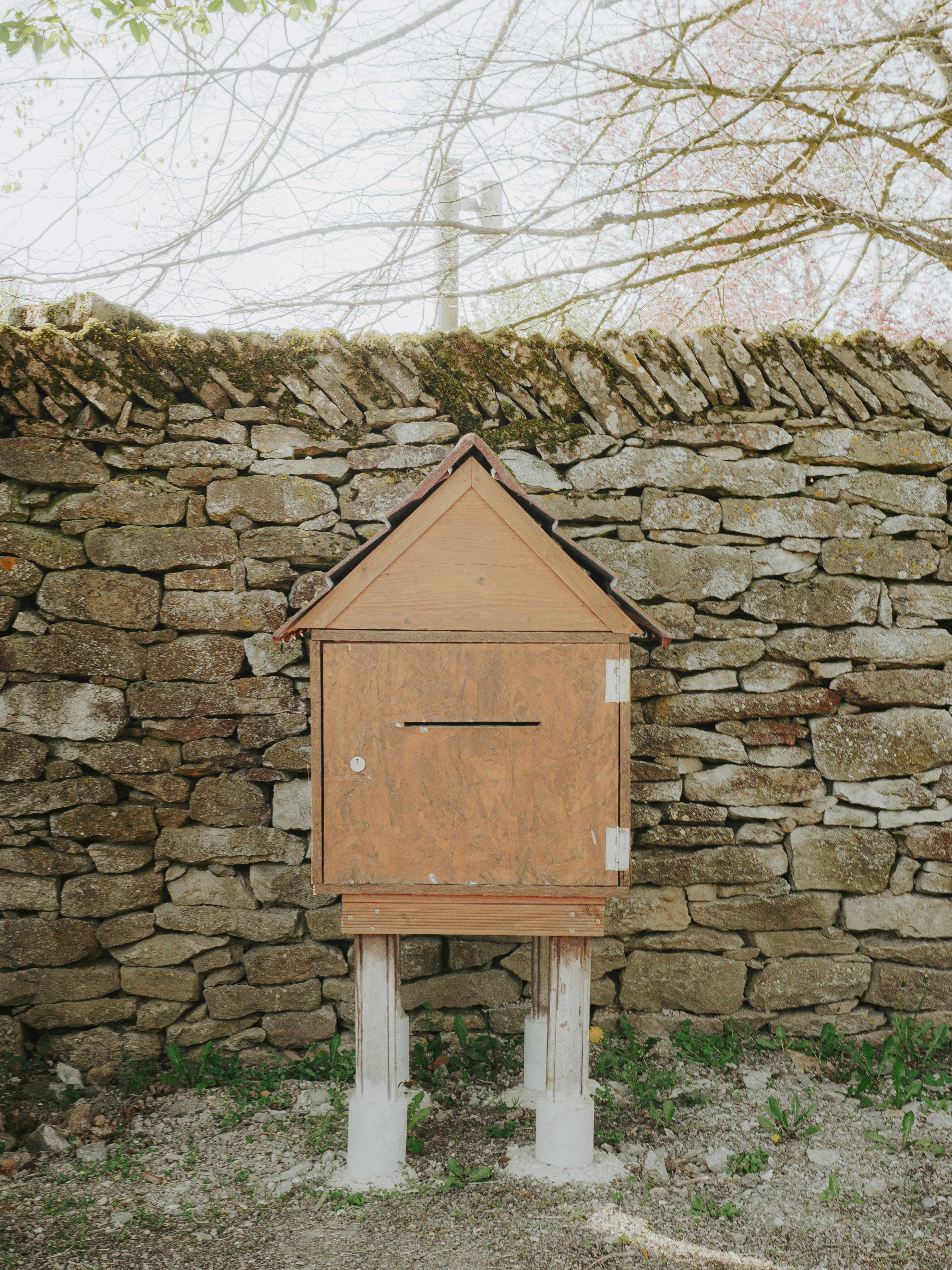 Weathered Mailbox Standing Guard Before a Dry-Stone Wall
