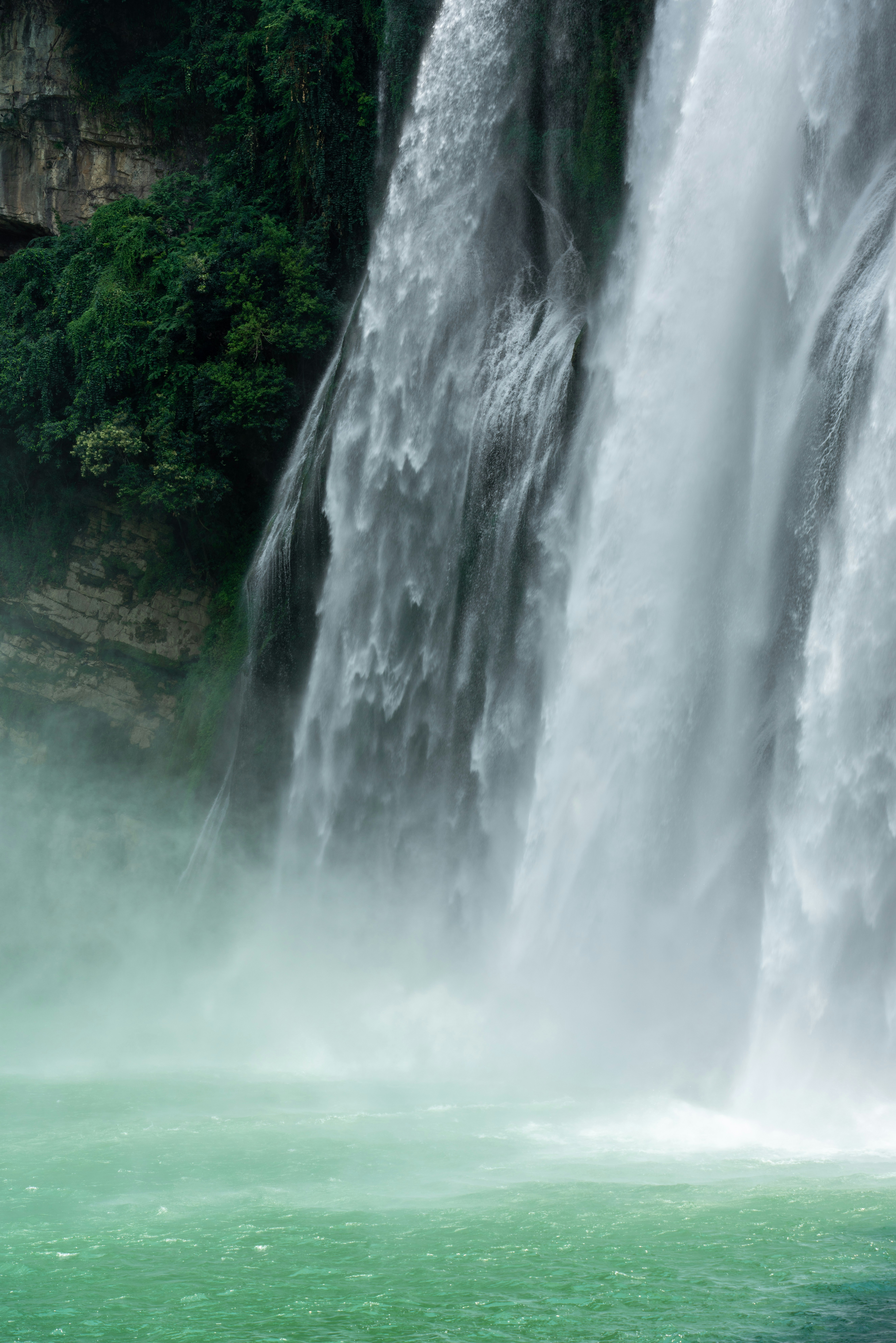 A powerful waterfall cascades down into the pool. photo – Free ...
