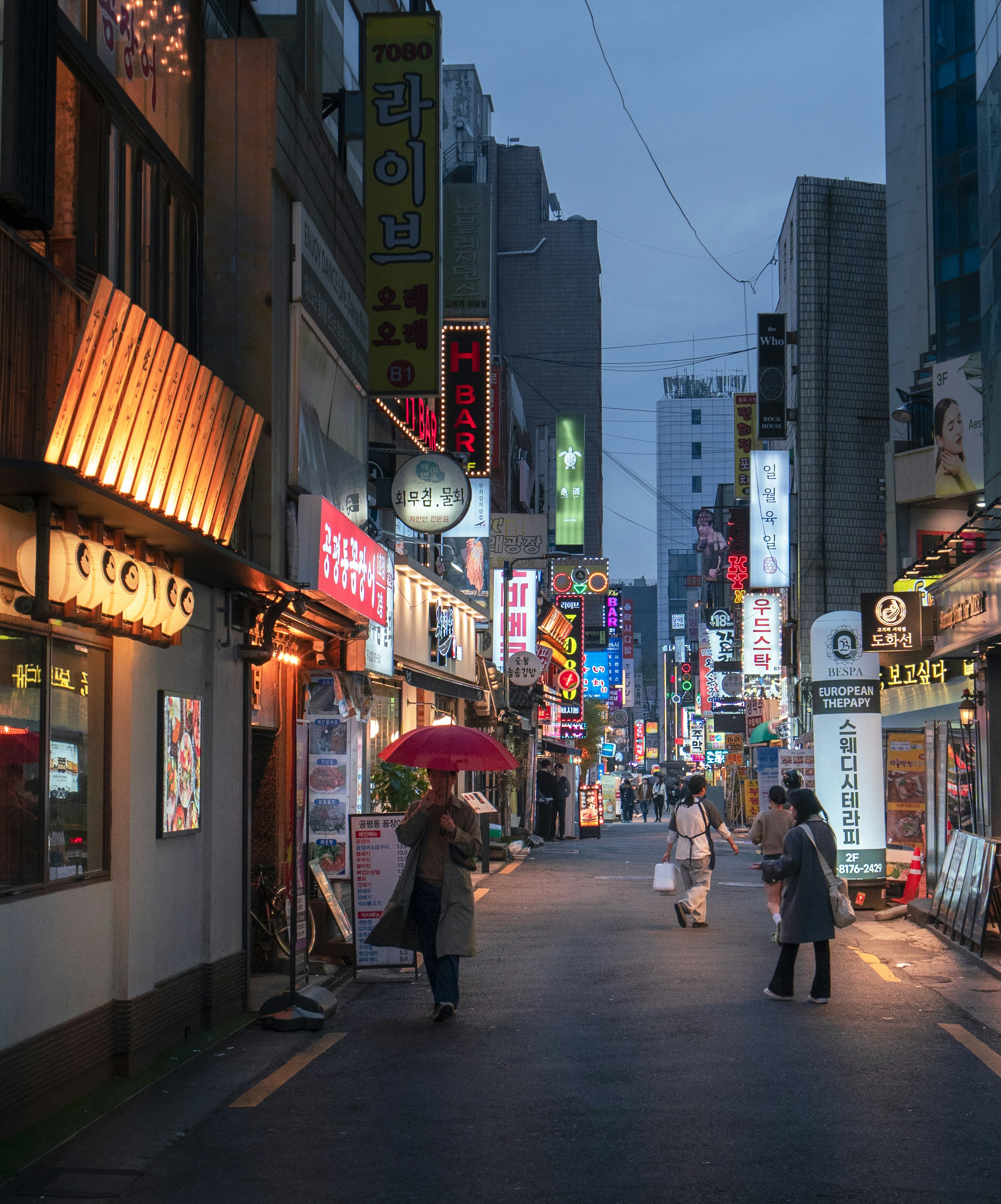 A narrow city street is lined with neon lights. photo – Free Travel ...