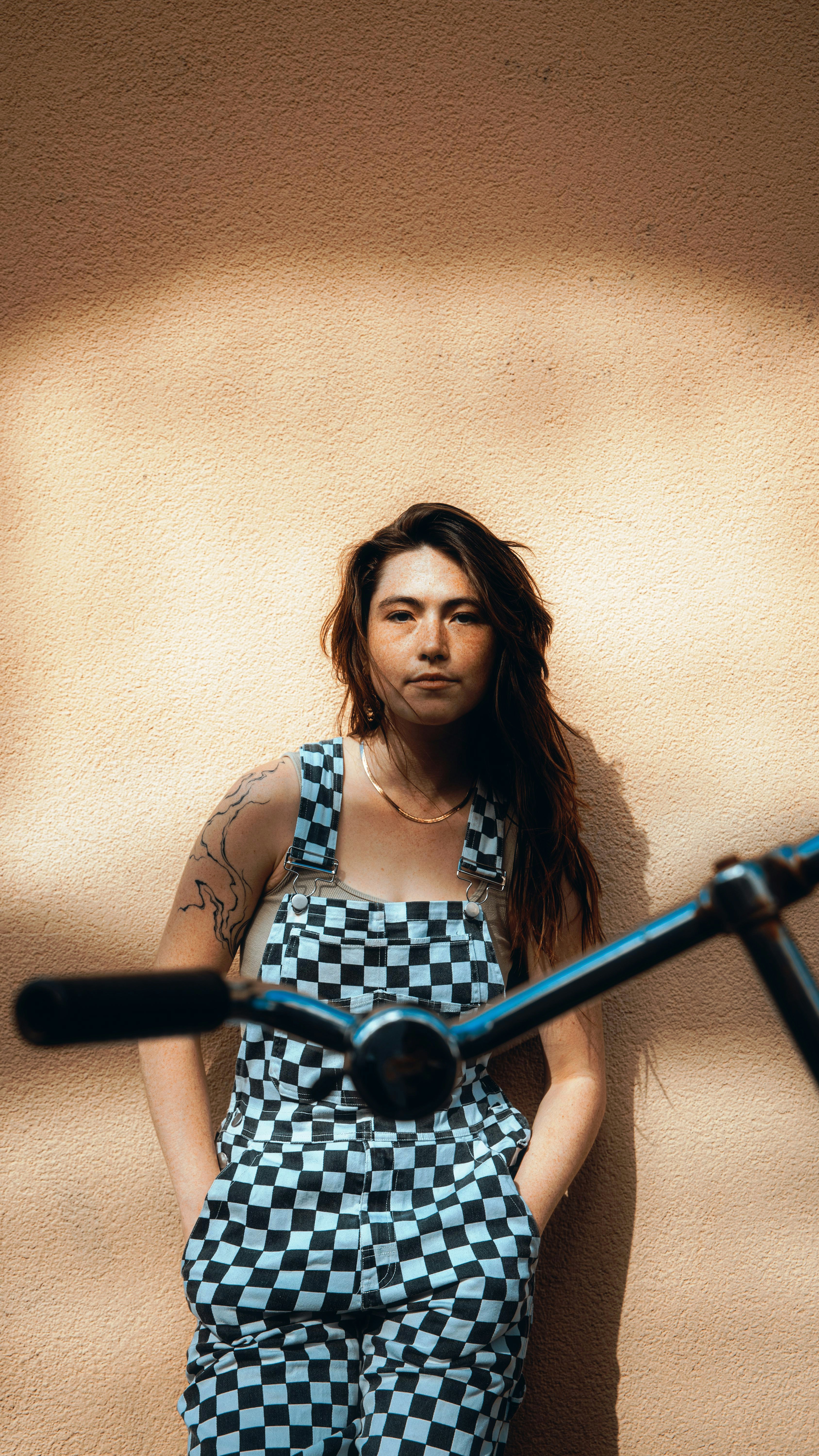 Una persona con overol está de pie junto a una bicicleta. foto – Imagen ...
