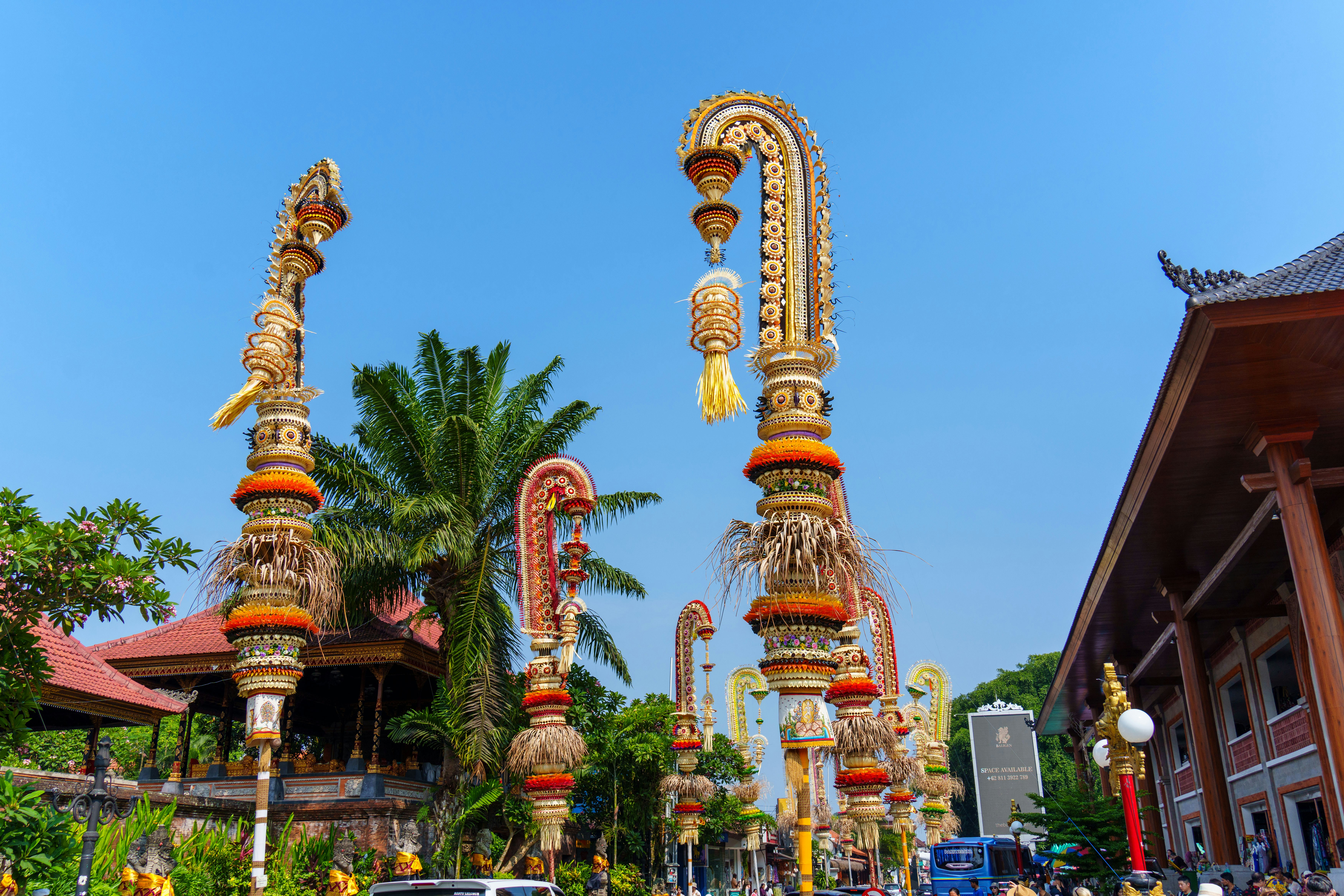 Sunlit Temple Street: A Row of Ornate Ceremonial Totems