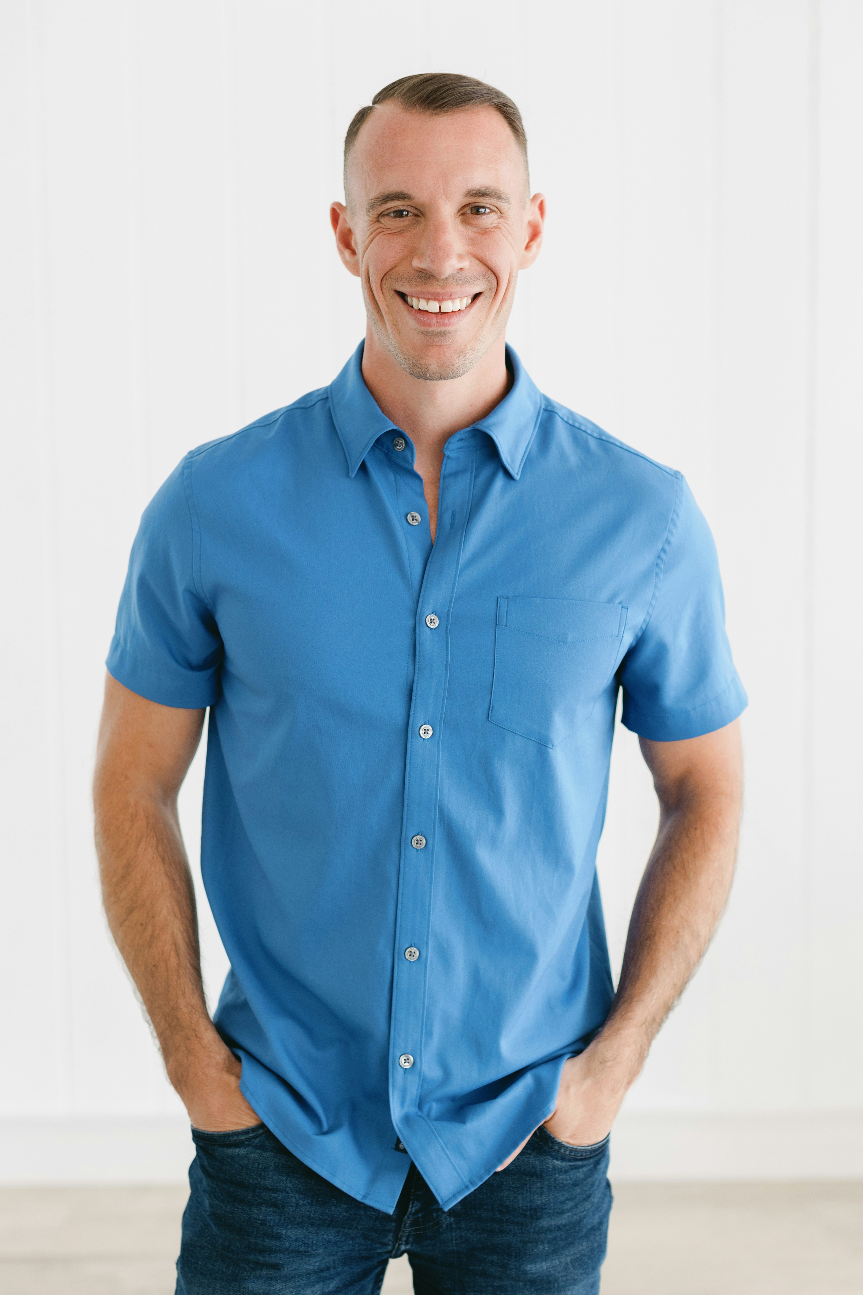 A smiling man poses in a blue shirt. photo – Free White background ...