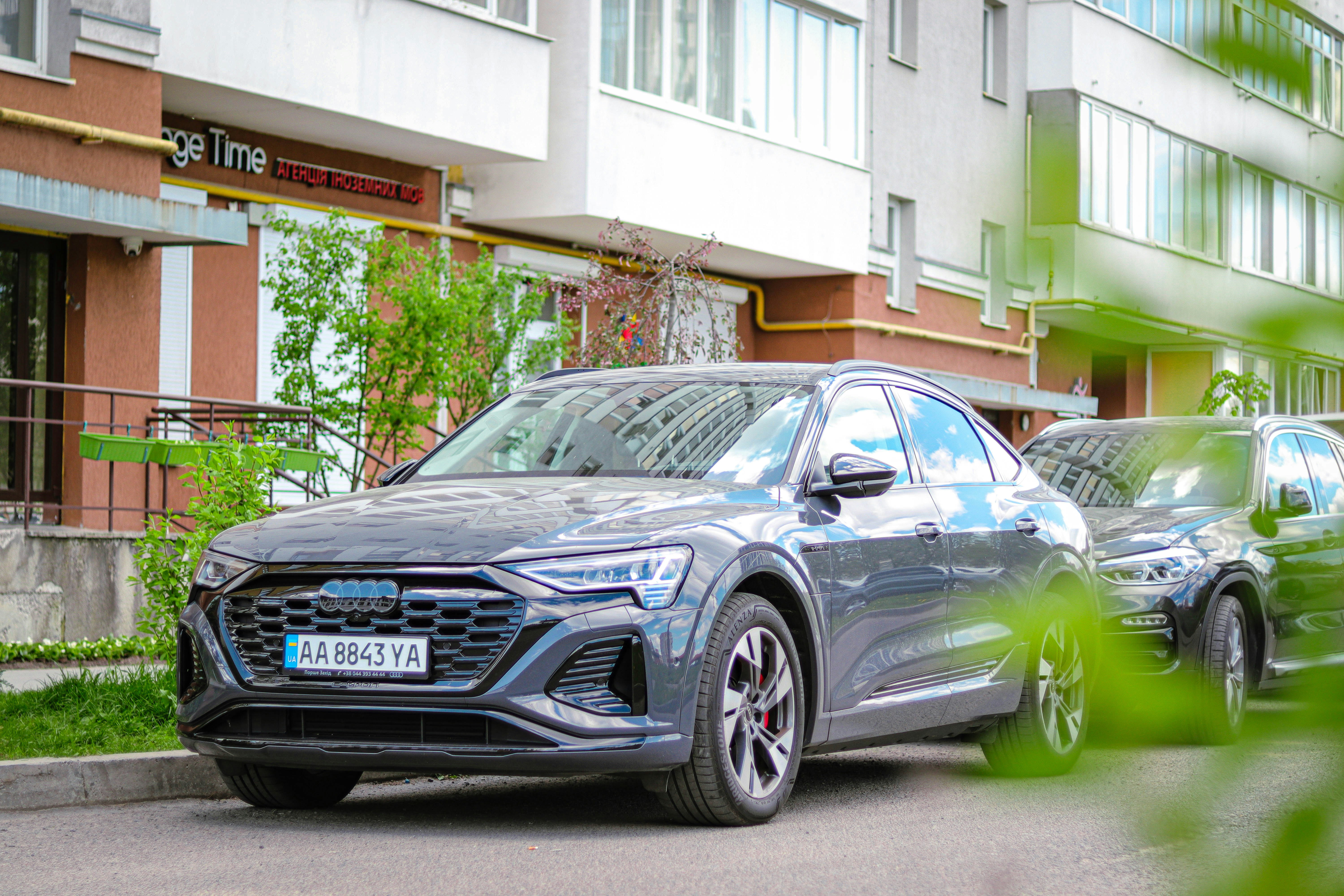 A gray audi suv is parked in front of a building. photo – Free ...