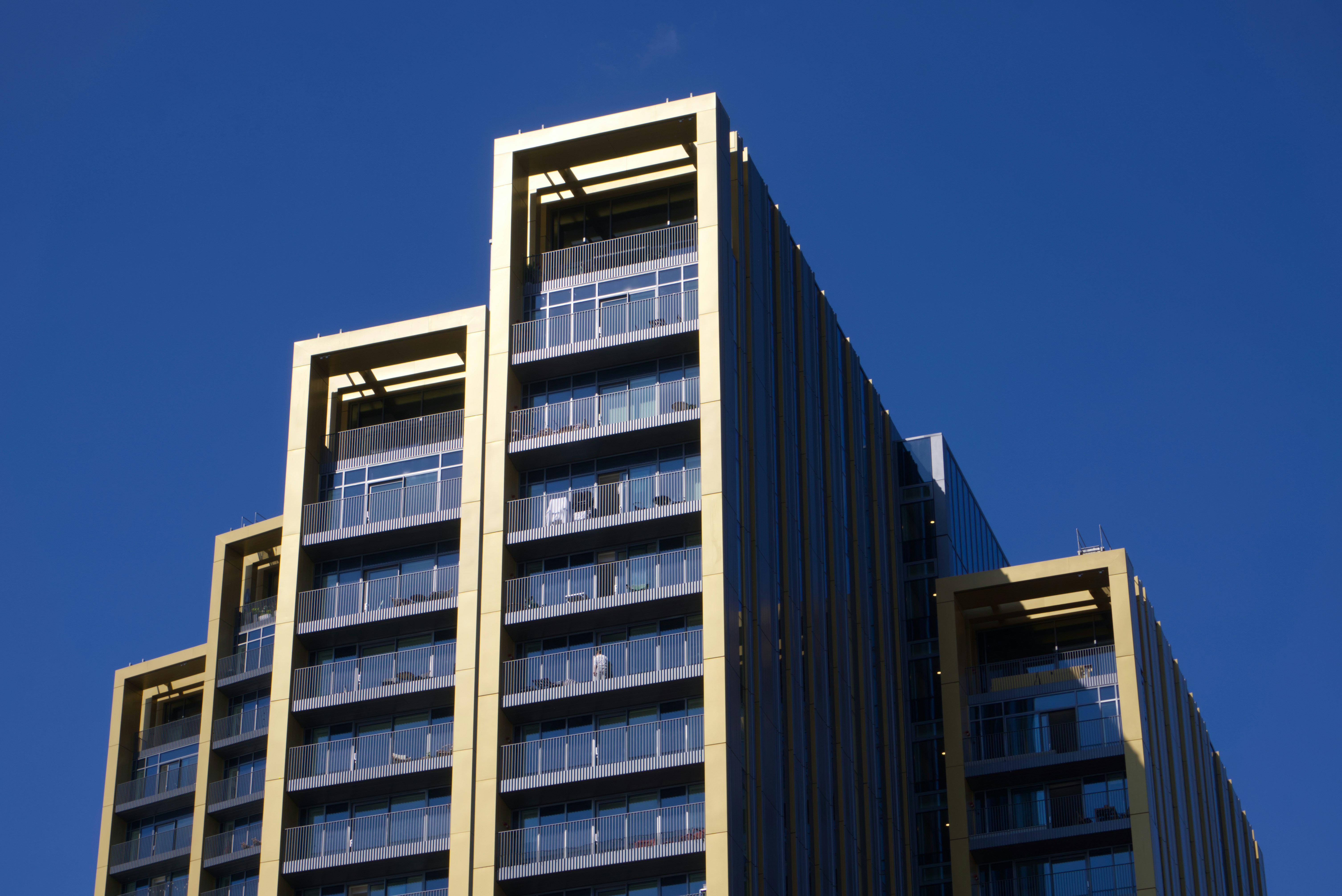 New Vic development, as viewed from the corner of Corporation Street and Balloon Street on a sunny Manchester afternoon. | Modern skyscraper with gold trim against a blue sky.