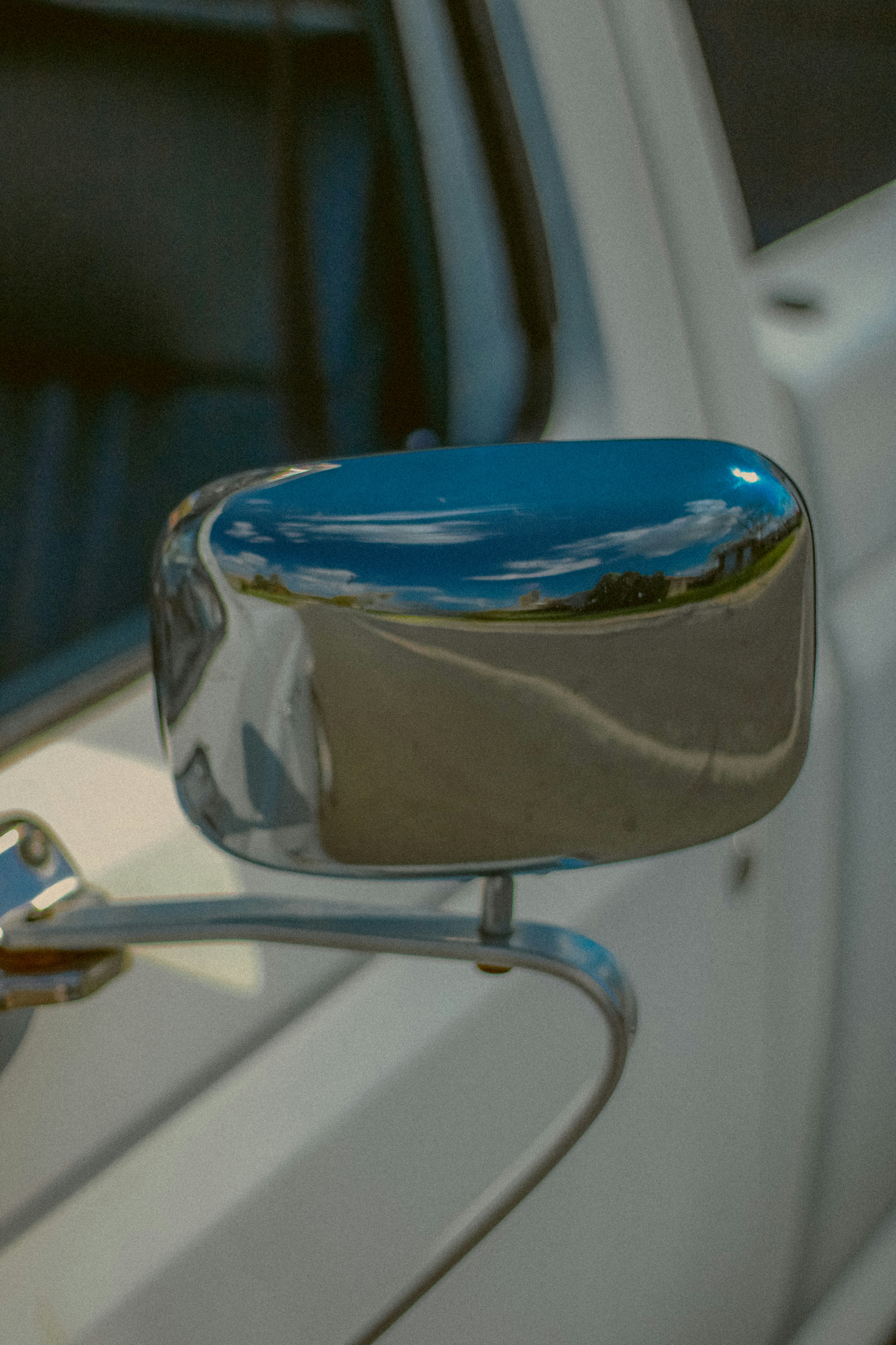 Chrome Side-Mirror Reflections: Sky, Road, and Quiet Drive