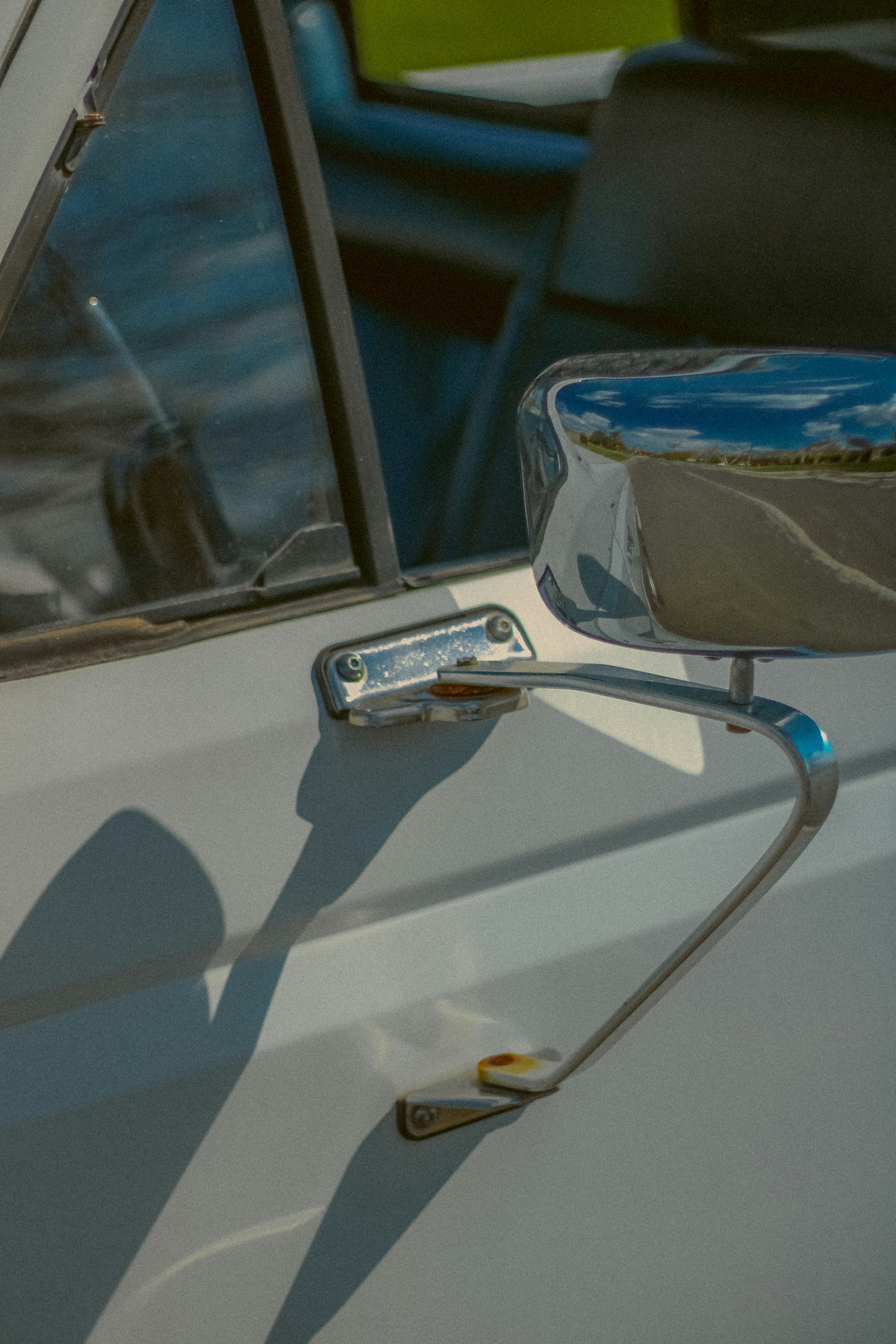 Chrome Echoes: A Vintage Car Door's Quiet Moment in Soft Light