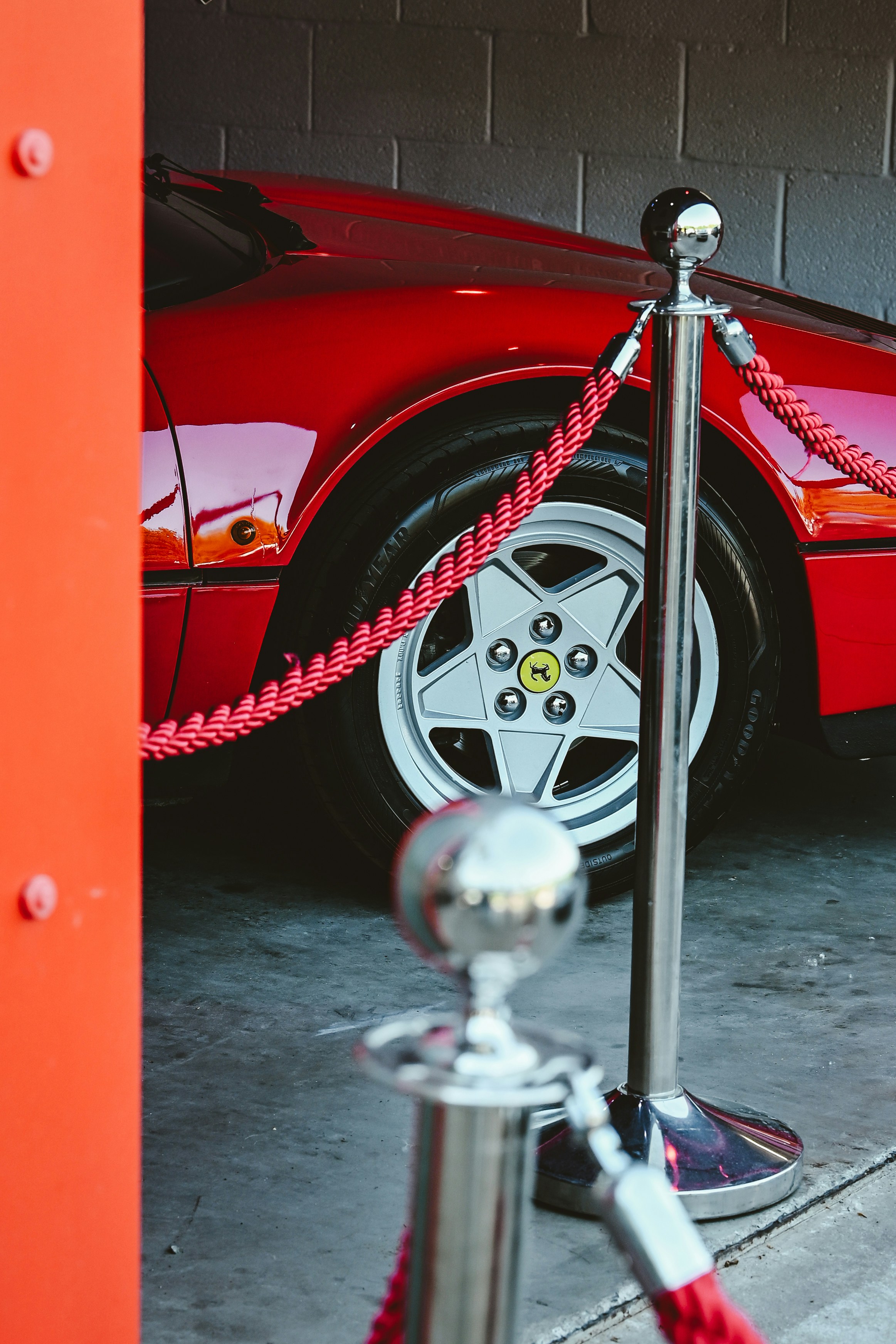 Ferrari F40 | A red ferrari is parked behind a rope barrier.