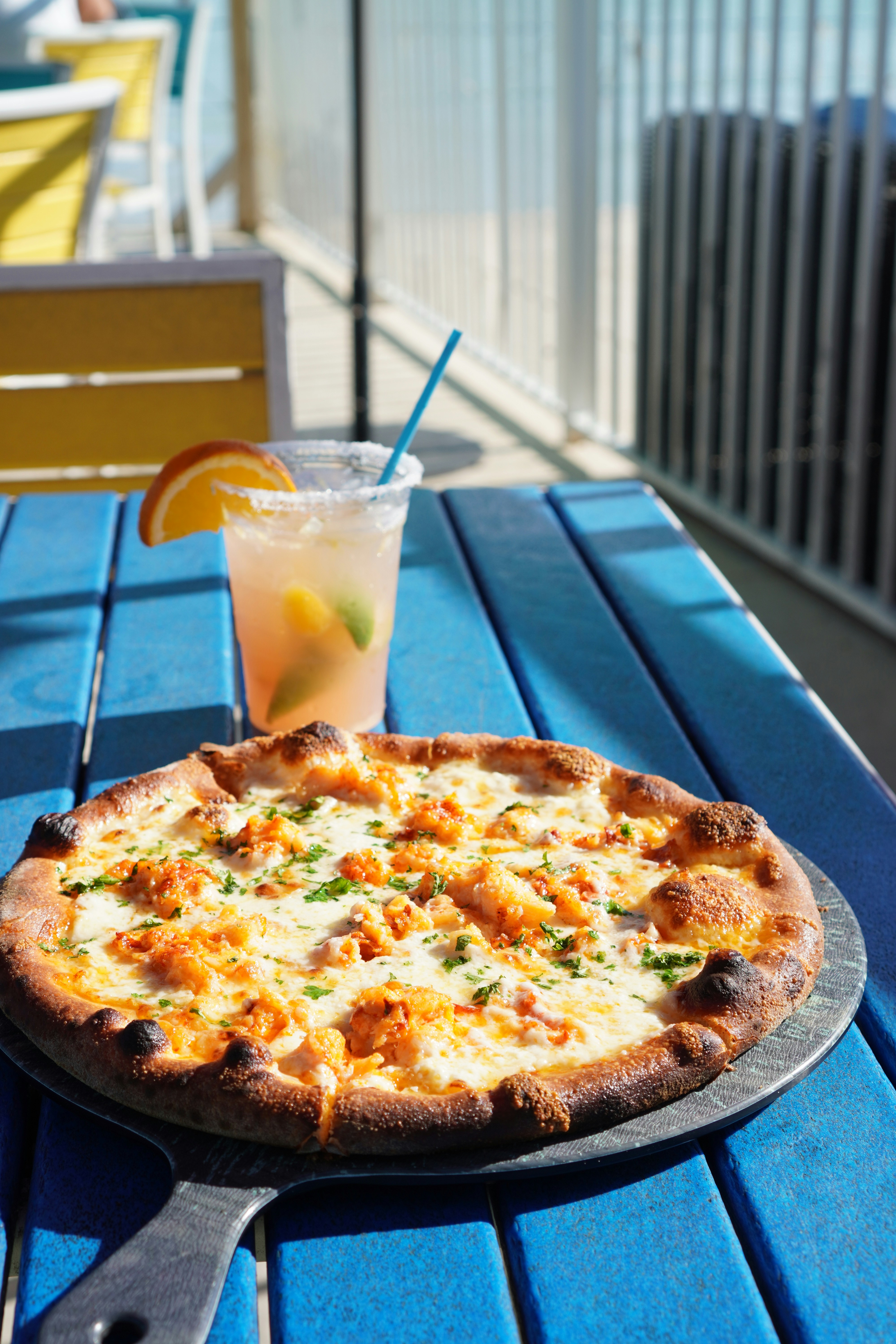 Cobalt Patio Pizza: Sunlit Slice on a Bright Outdoor Table