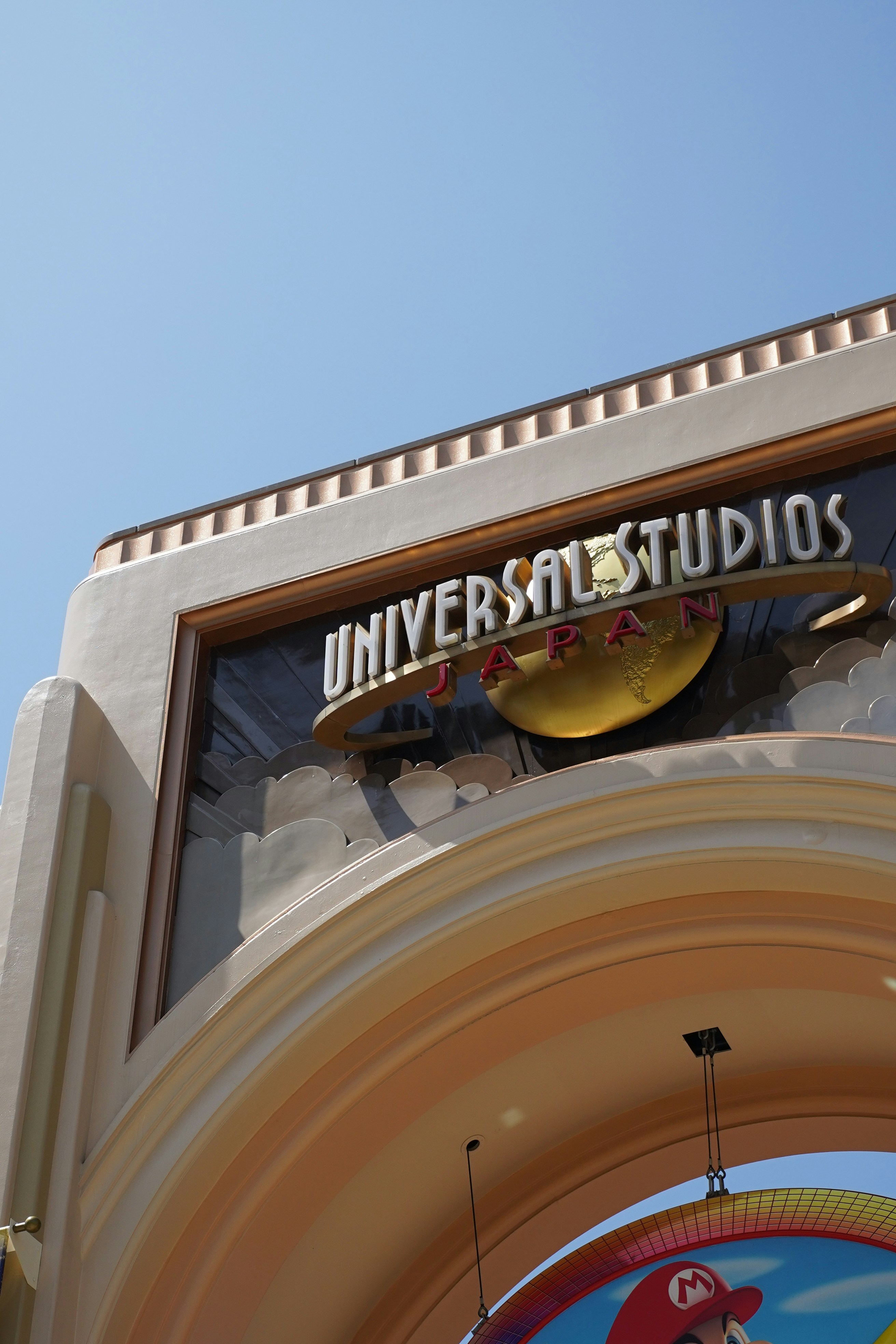 The iconic entrance of Universal Studios Japan, featuring the logo and vibrant design elements under a clear blue sky.
