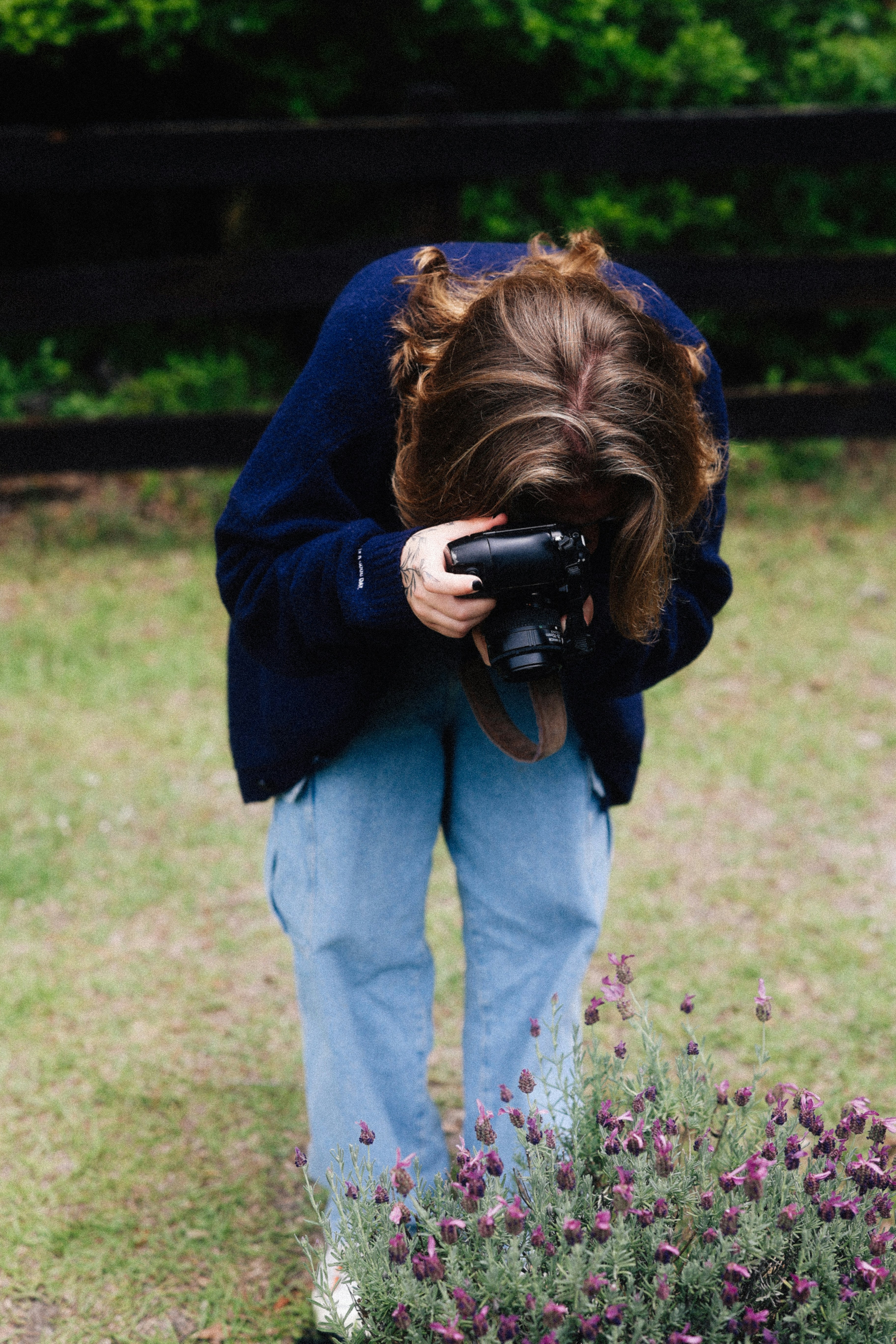 Crouched Photographer Framing a Quiet Field Moment